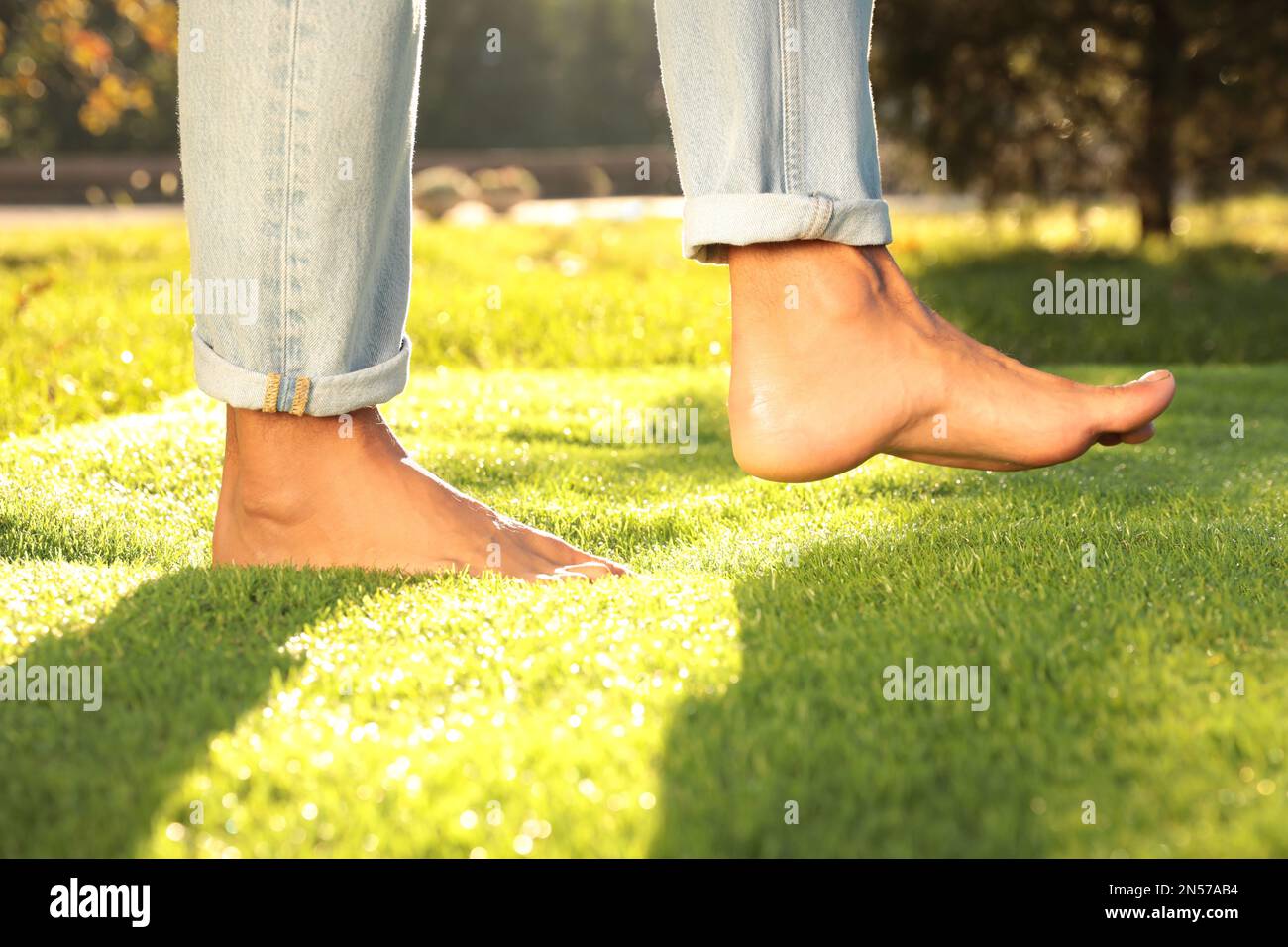 Man walking barefoot on fresh green grass, closeup Stock Photo - Alamy