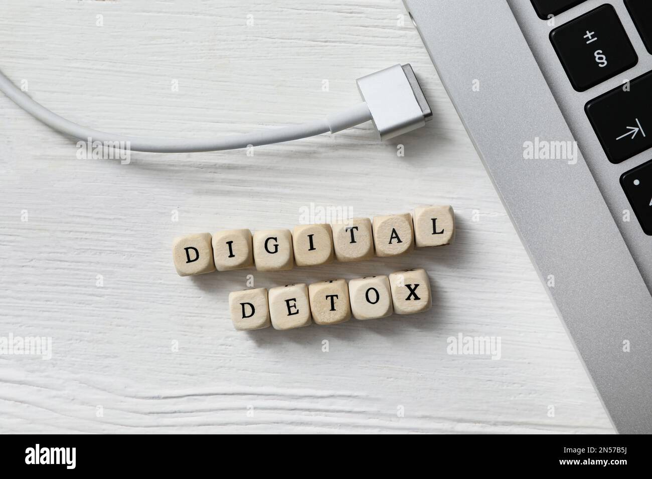 Cubes with words DIGITAL DETOX and disconnected charging cable on white ...