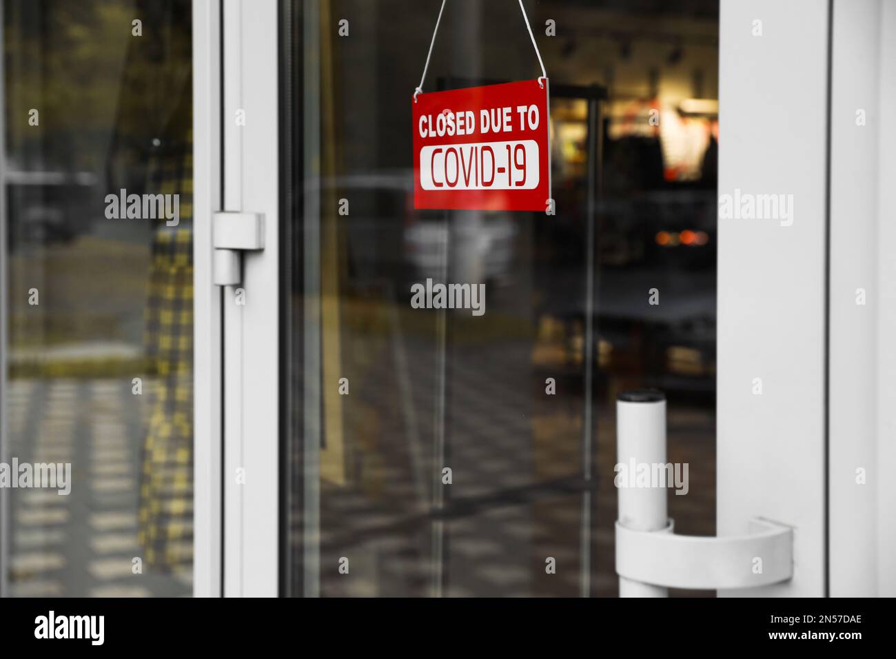 Red sign with words "Closed Covid-19" hanging on glass door Stock Photo ...