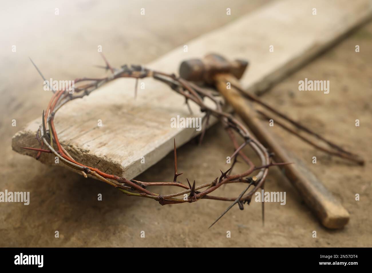 Crown of thorns, hammer and wooden plank on ground. Easter attributes ...