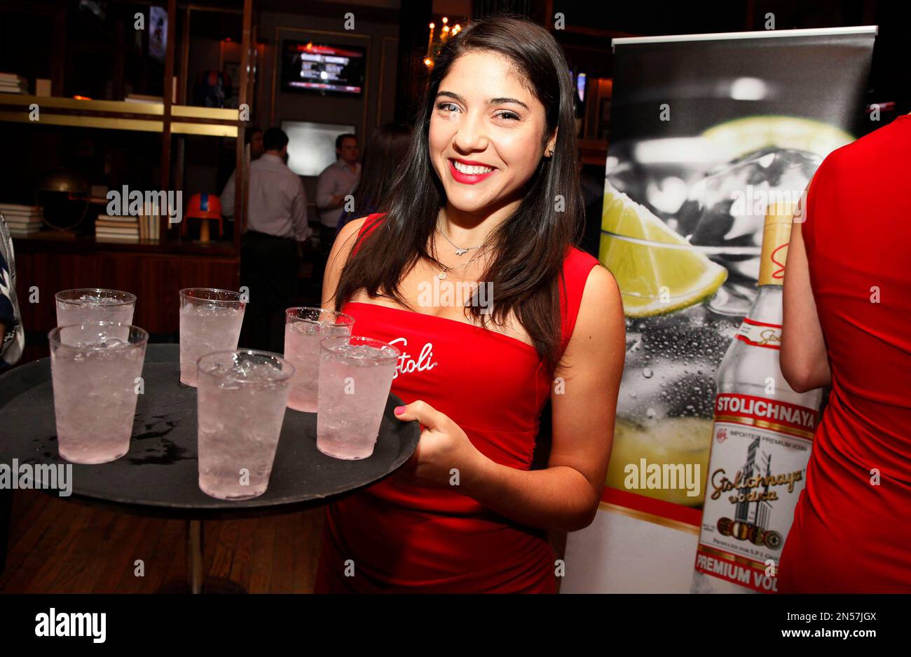 Waitress serves Stoli® drinks while waiting for Manhattan bartender ...