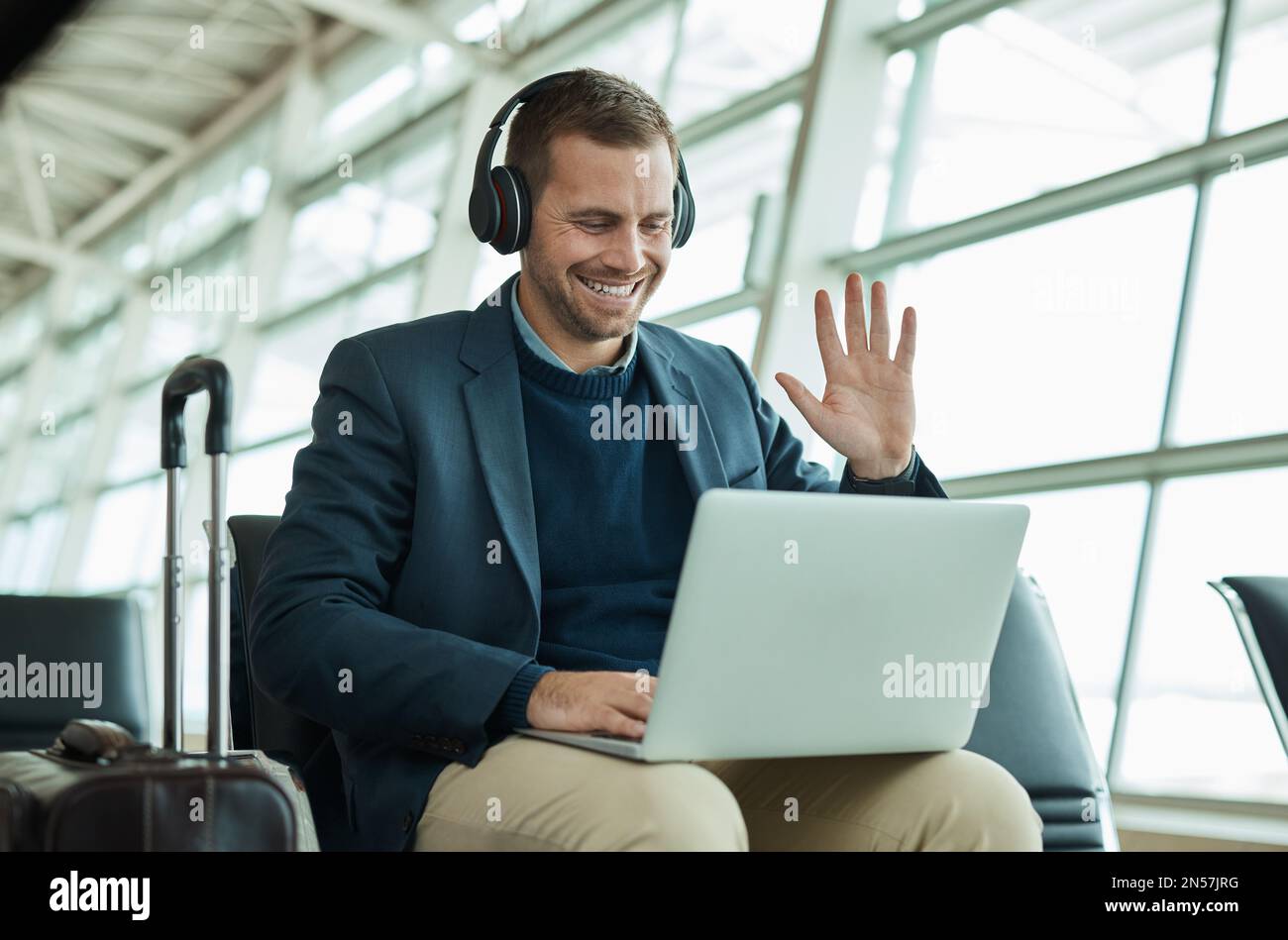 Computer call, wave and business man at an airport in a online meeting ...