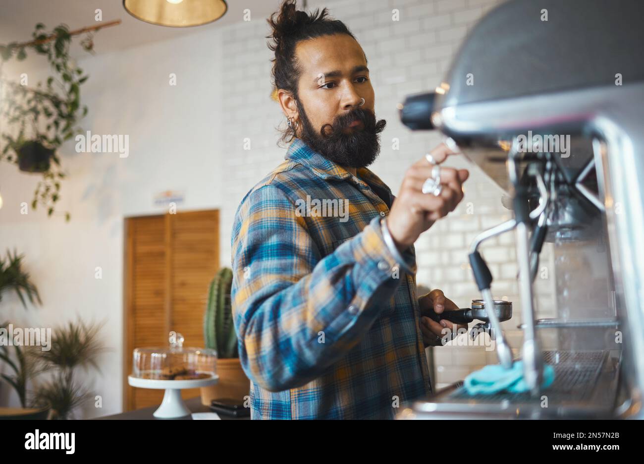 Man in cafe, barista work machine and create drink with focus and small ...