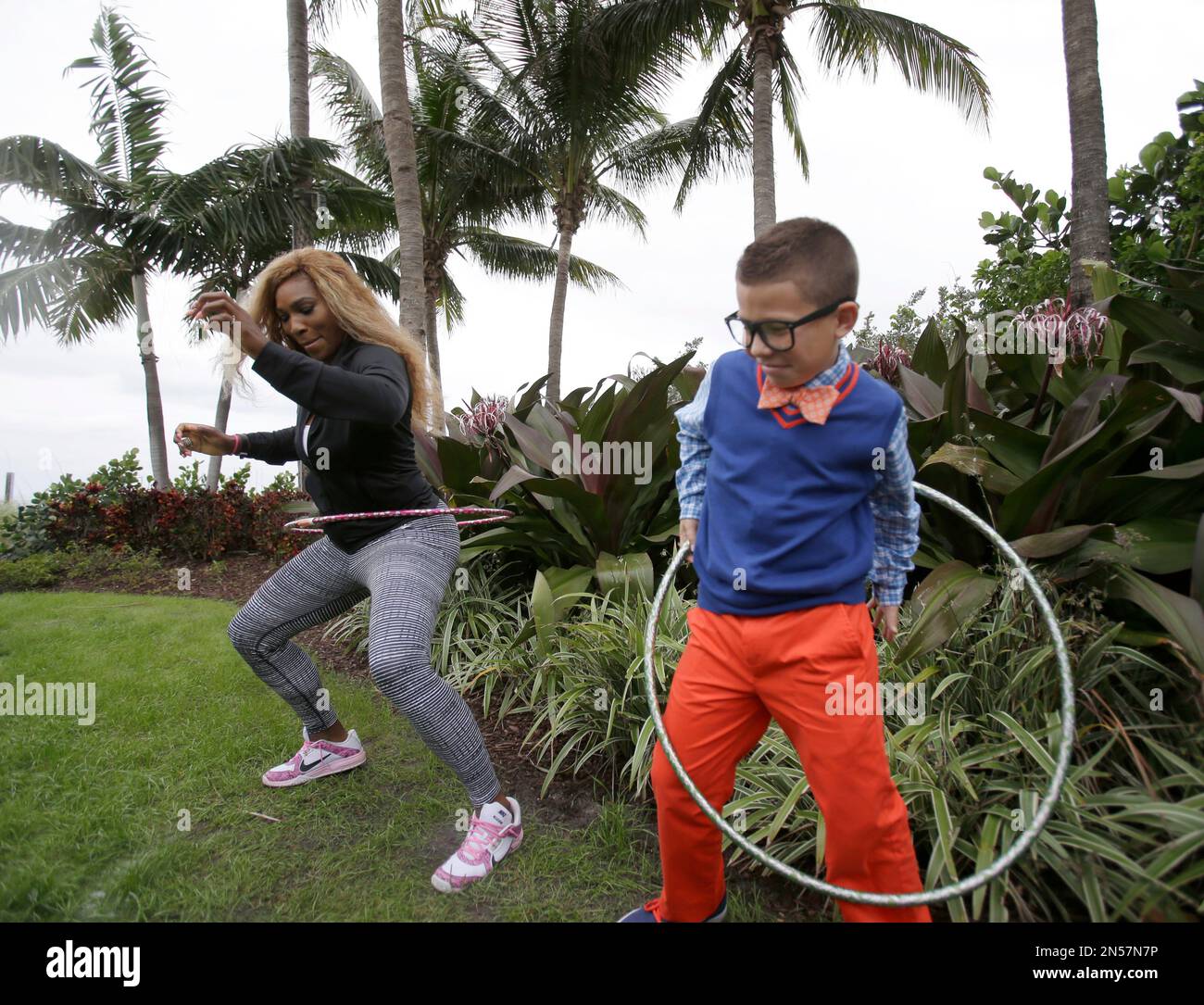 Serena Williams, left, takes her turn with a hula hoop during an ...