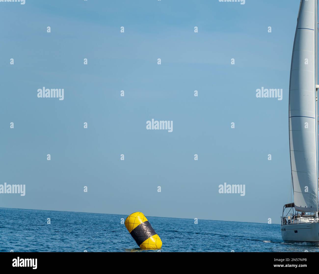 Half sailboat, tilted sea and yellow buoy with text space Stock Photo ...