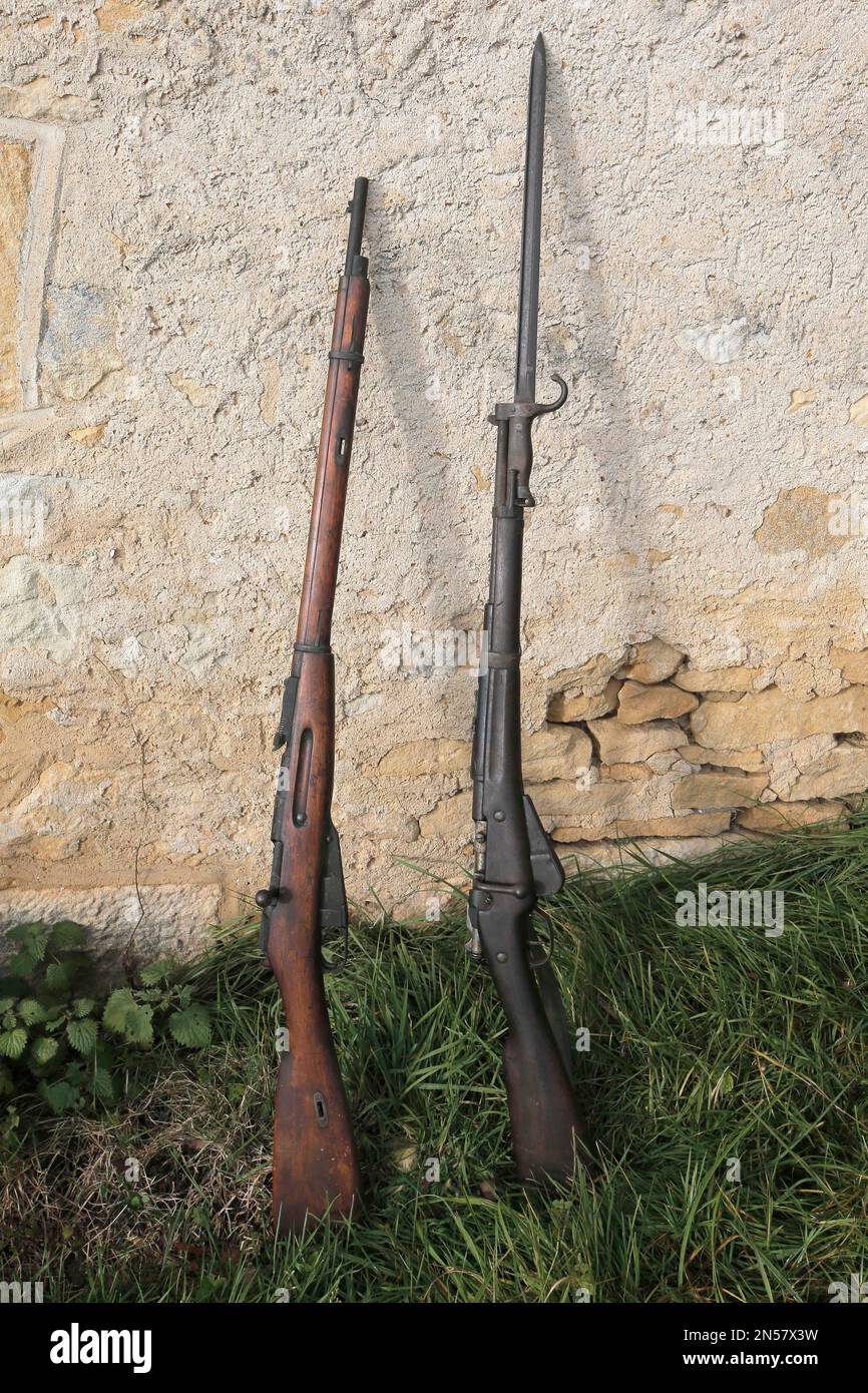 Two Word War One era rifles, one with an attached bayonet, lean against ...