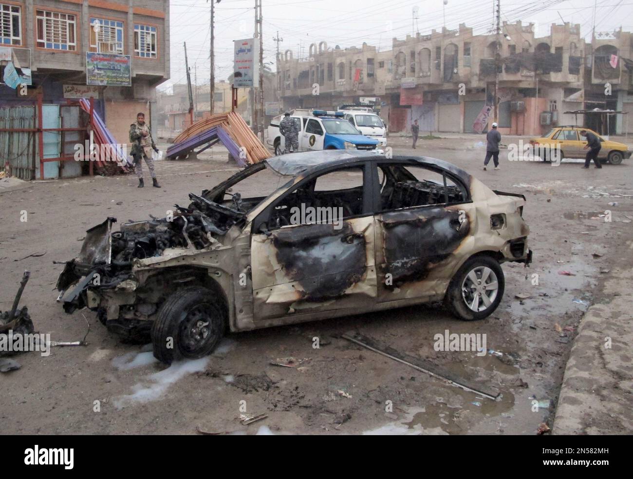 People and security forces inspect the site of a car bomb explosion at ...