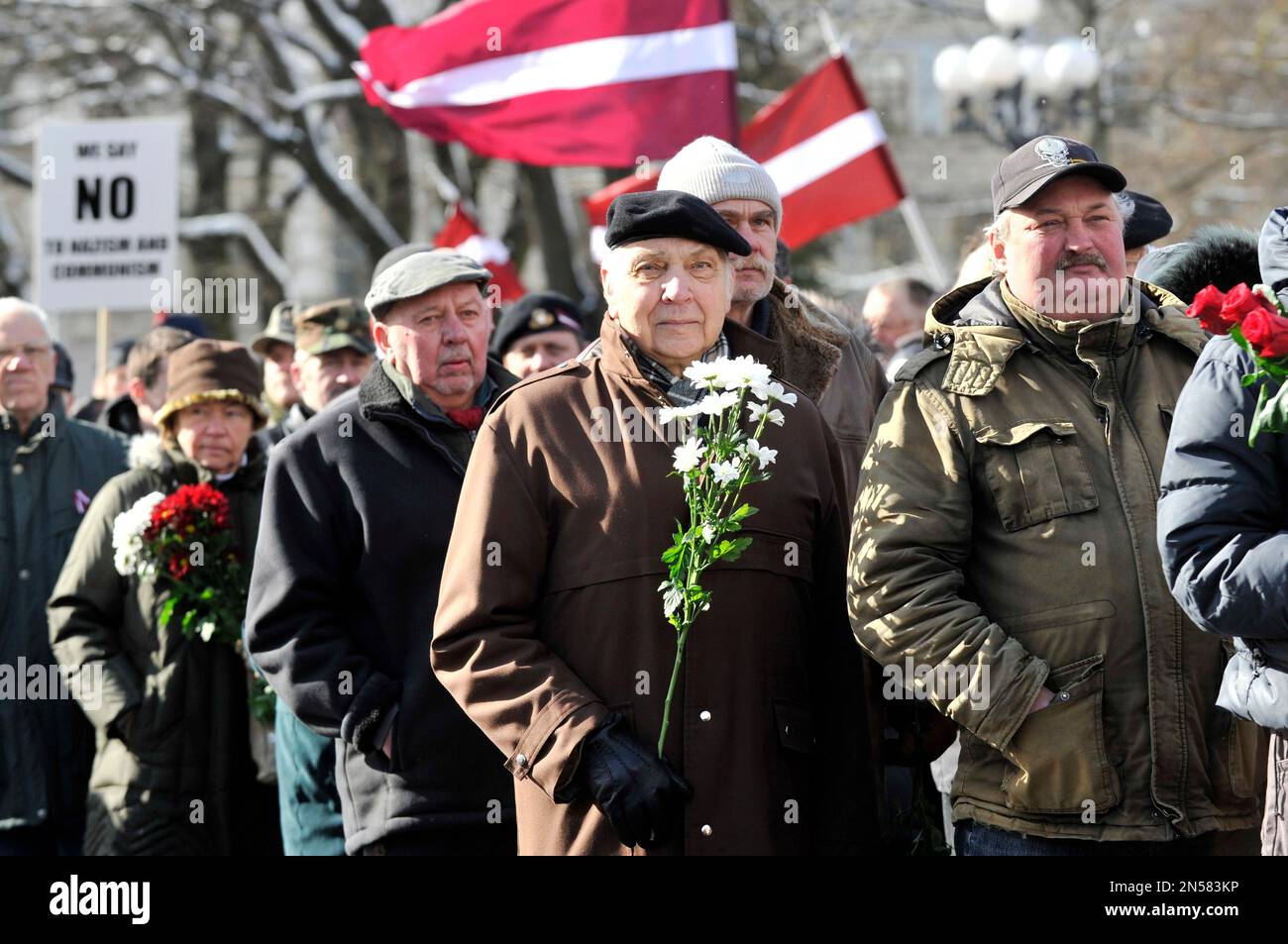People carry Latvian flags as they march to the Freedom Monument to ...