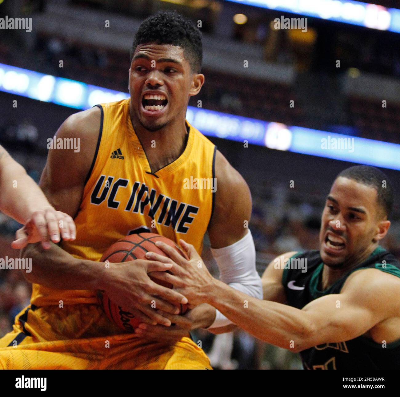 Cal Poly guard Jamal Johnson, right, ties up the ball held by UC Irvine ...