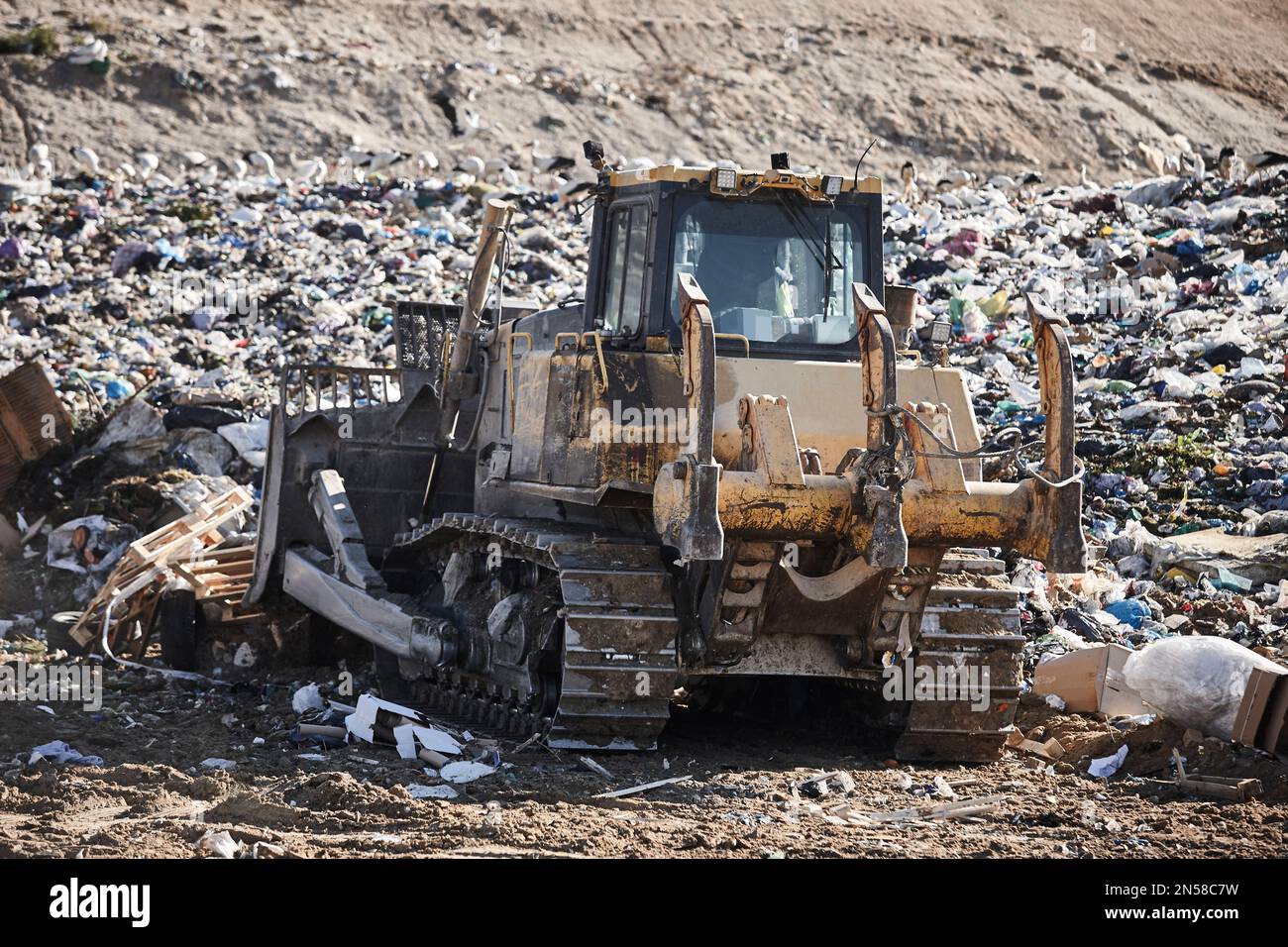 Heavy machinery shredding garbage in an open air landfill. Waste Stock ...
