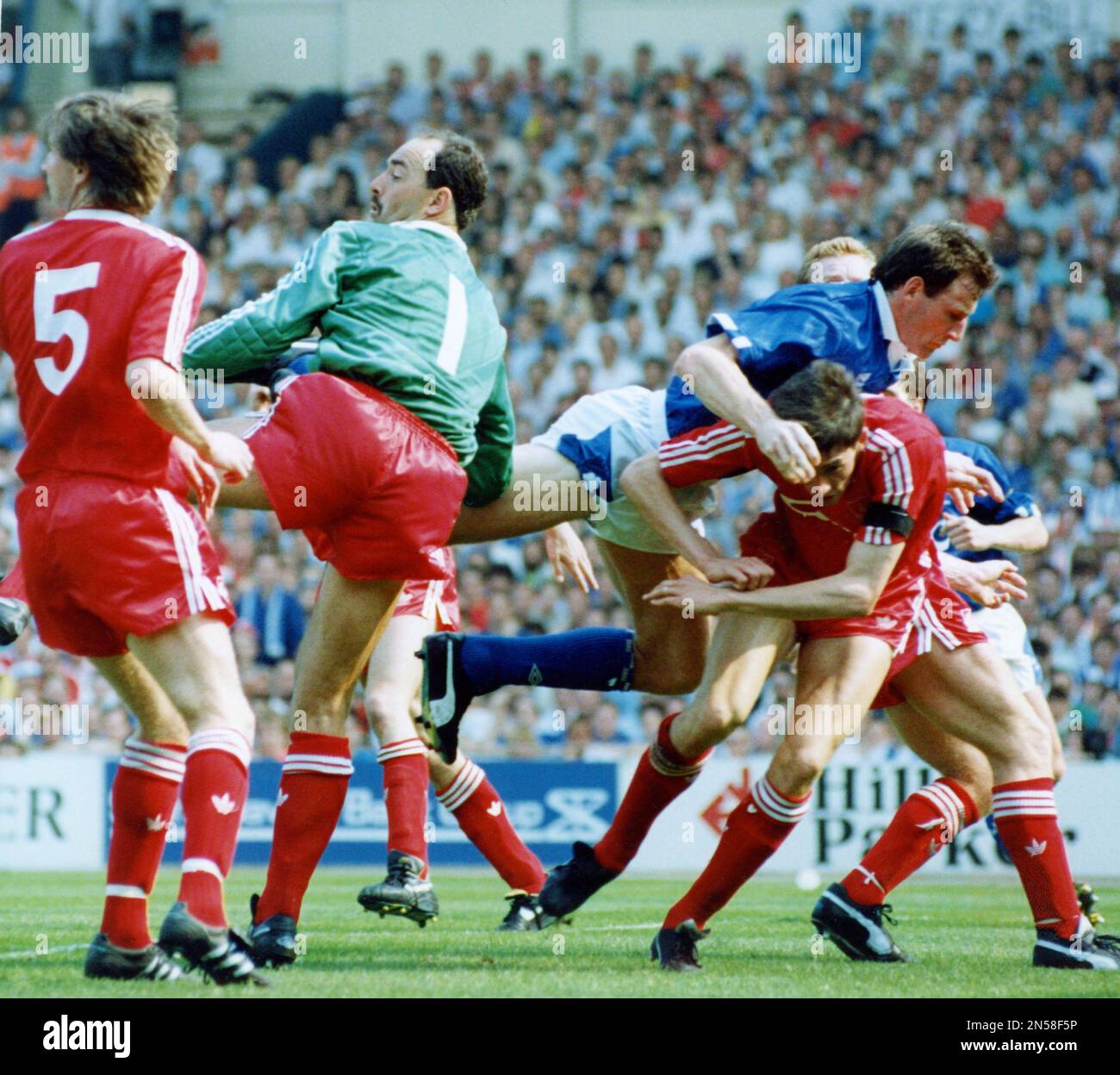 Everton's Dave Watson seems to climb all over Liverpool's Gary Ablett ...