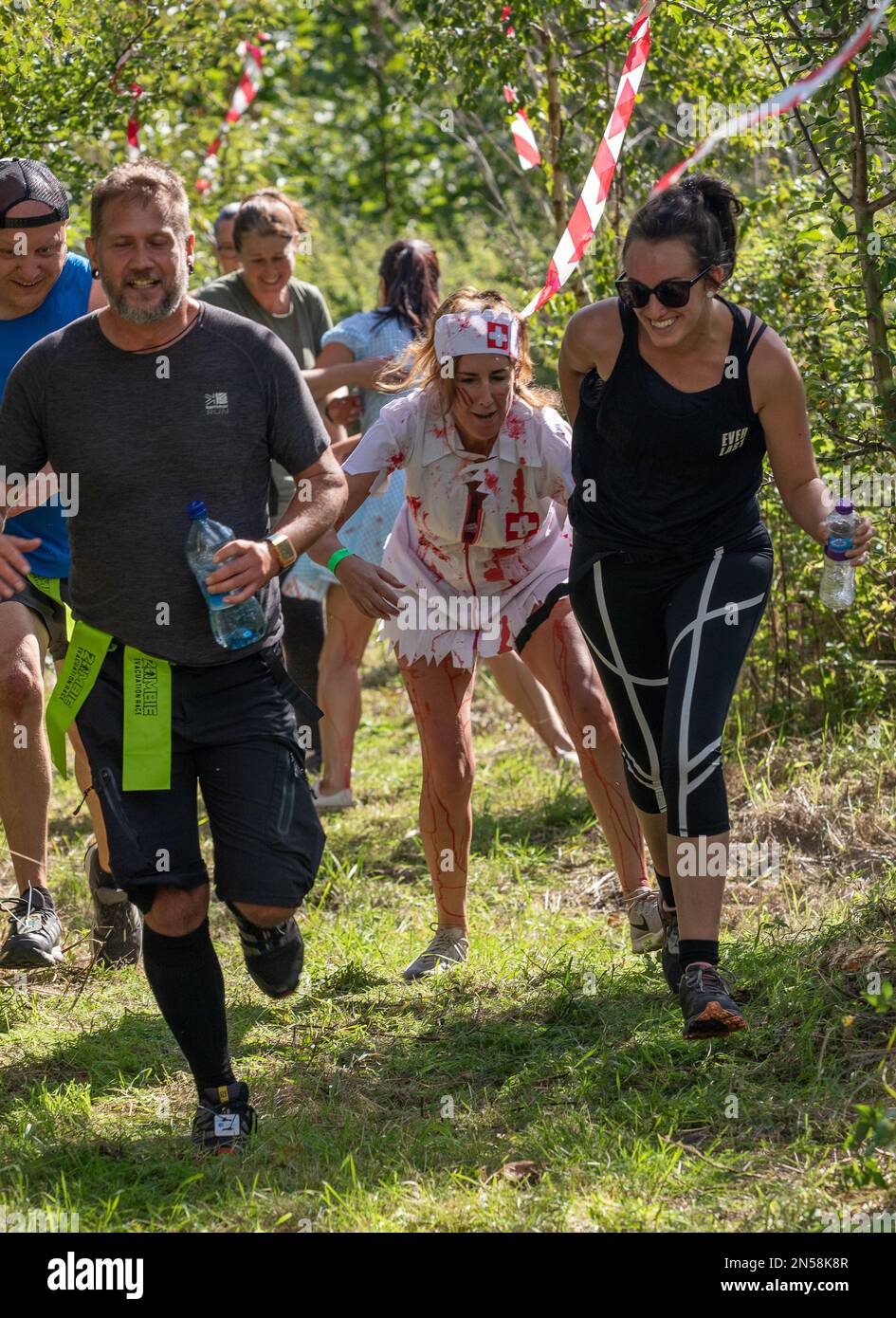 Runners on a Zombie Evacuation assault course try to avoid having their ...