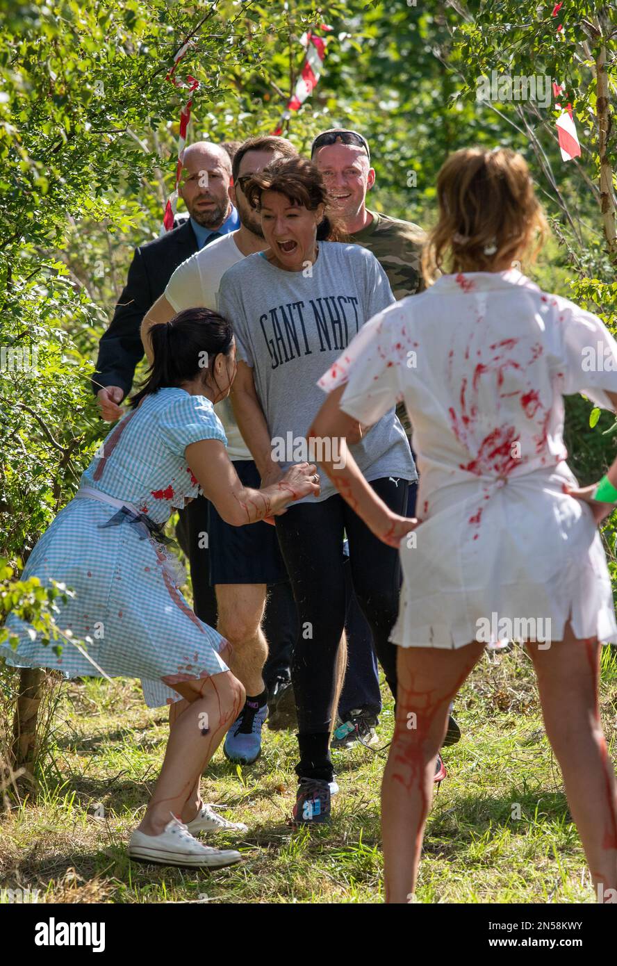 Runners on a Zombie Evacuation assault course try to avoid having their ...