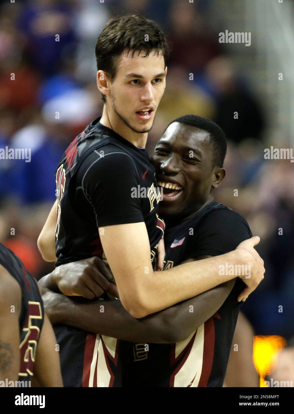 Florida State's Boris Bojanovsky, left, is lifted by Michael Ojo, right ...