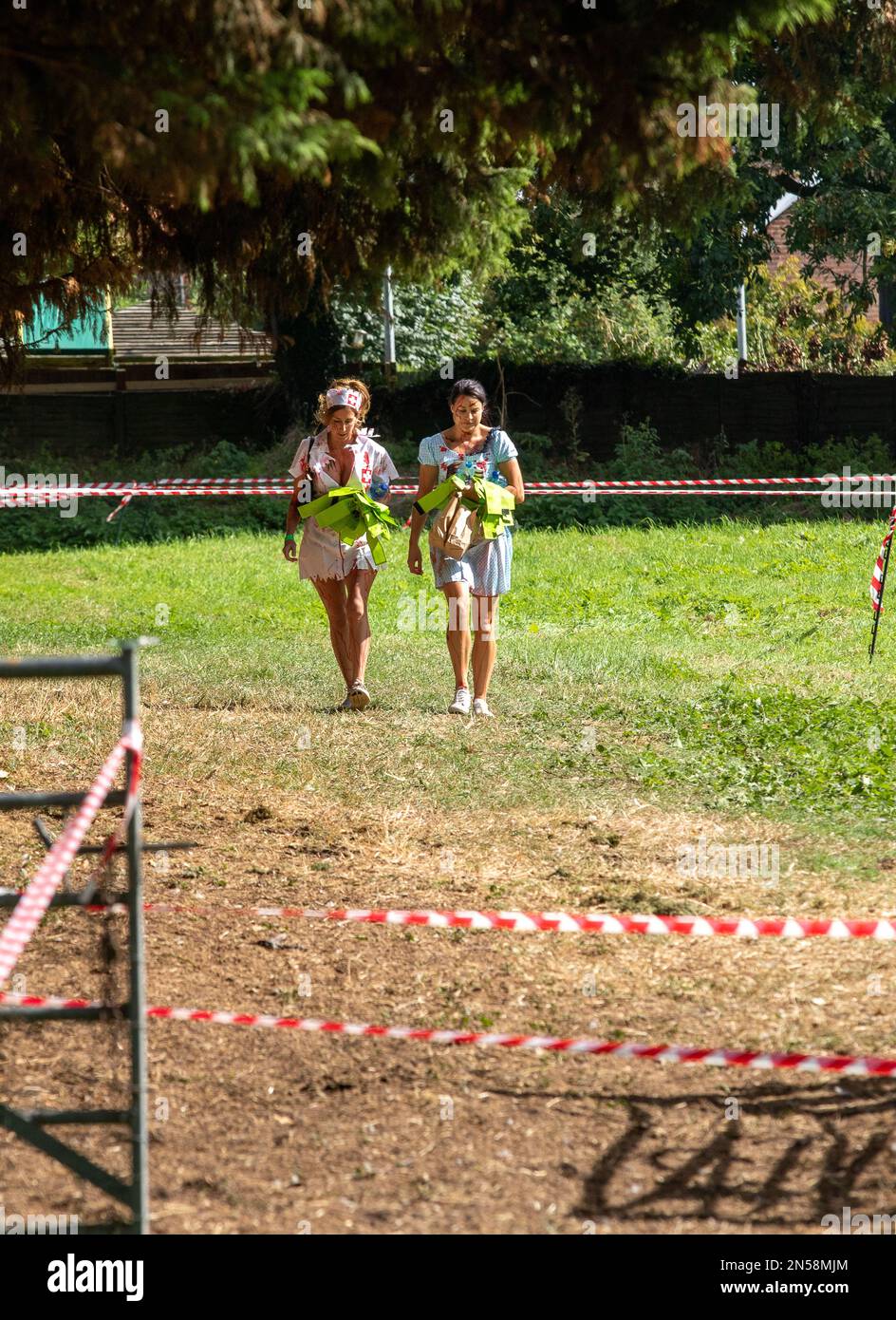 A zombie nurse and girl next door walk back carrying the streamers they ...