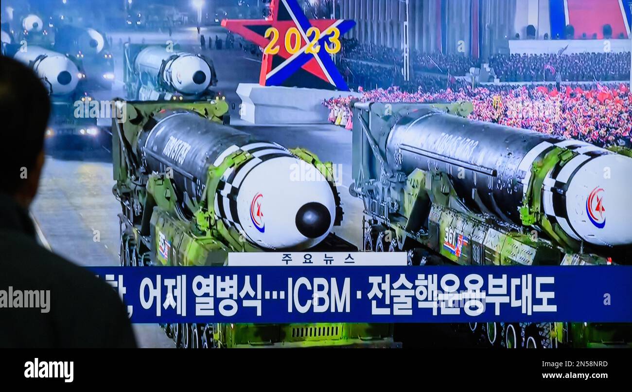 People watch a television screen showing a news broadcast with an image ...