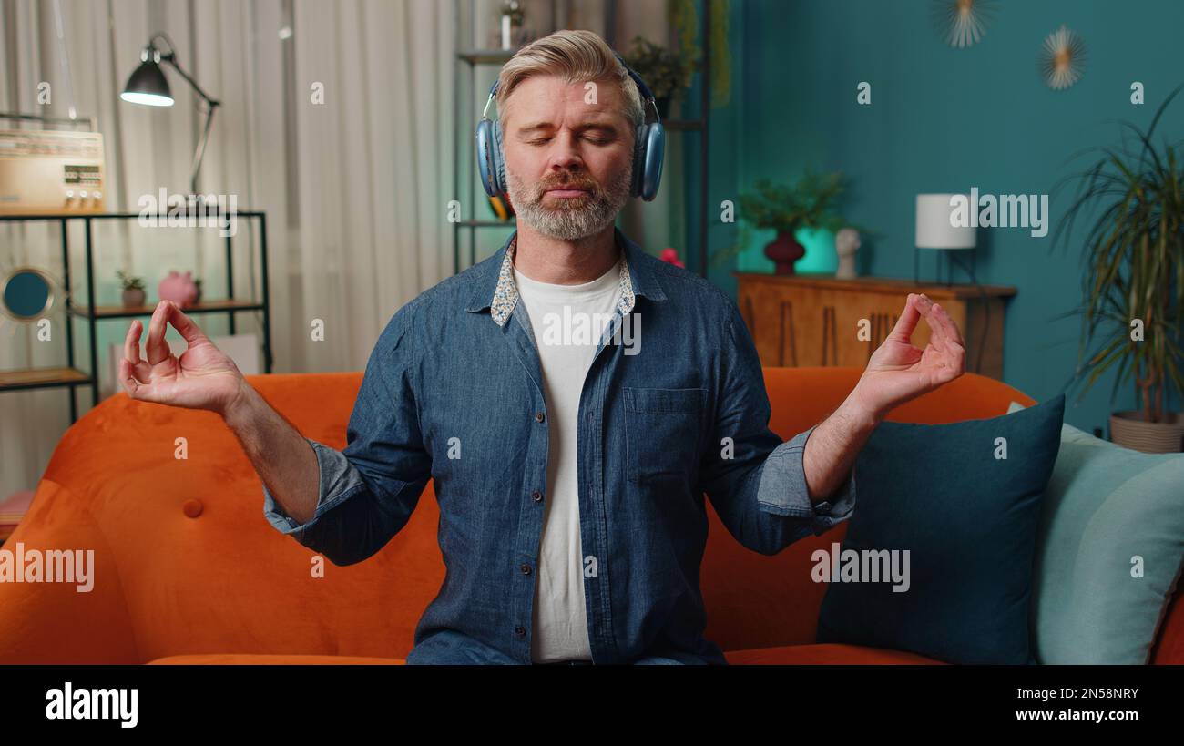 Keep calm down, relax. Middle-aged old man at home couch breathes ...