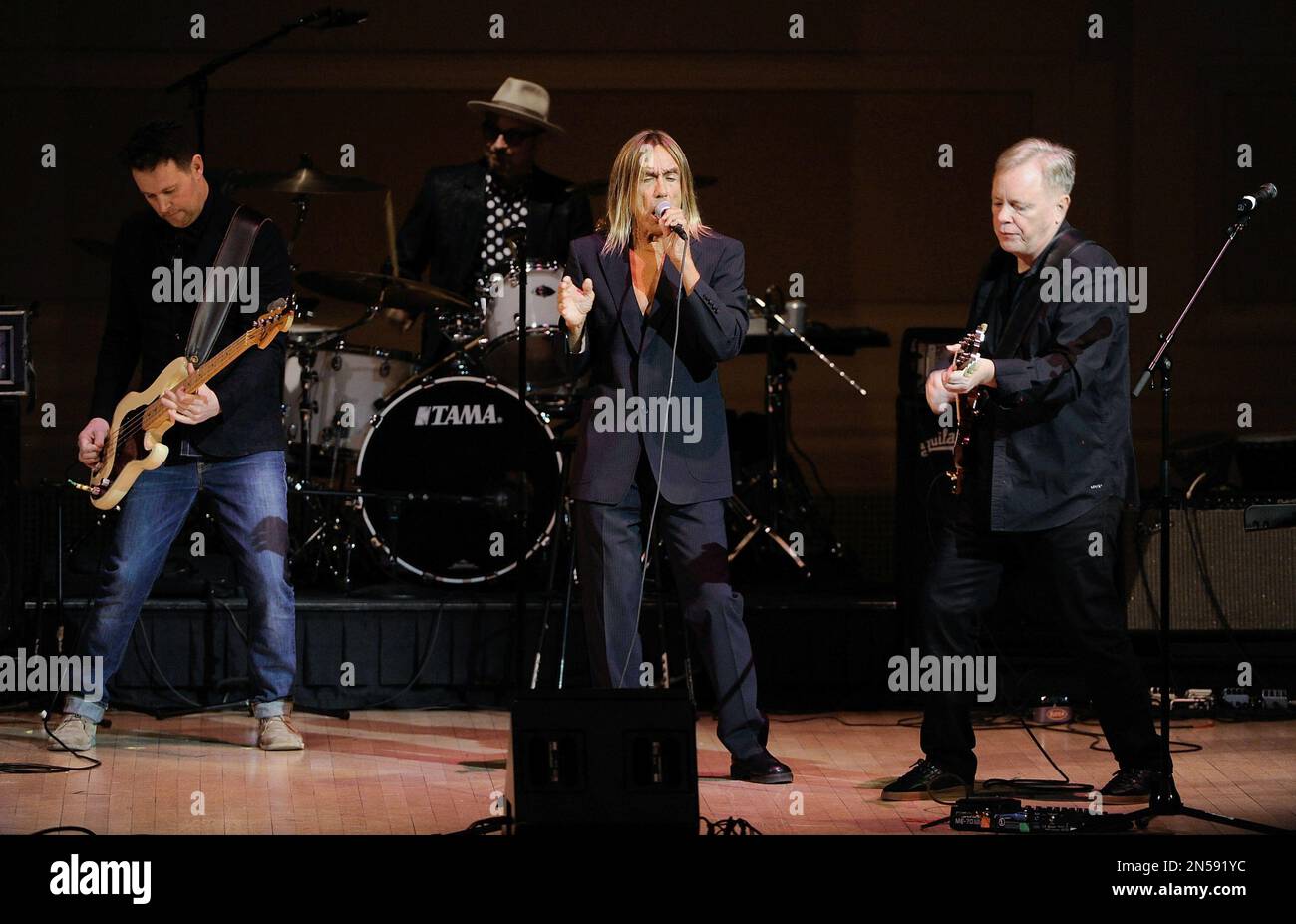 Singer Iggy Pop, center, performs with Bernard Sumner, right, and Tom ...