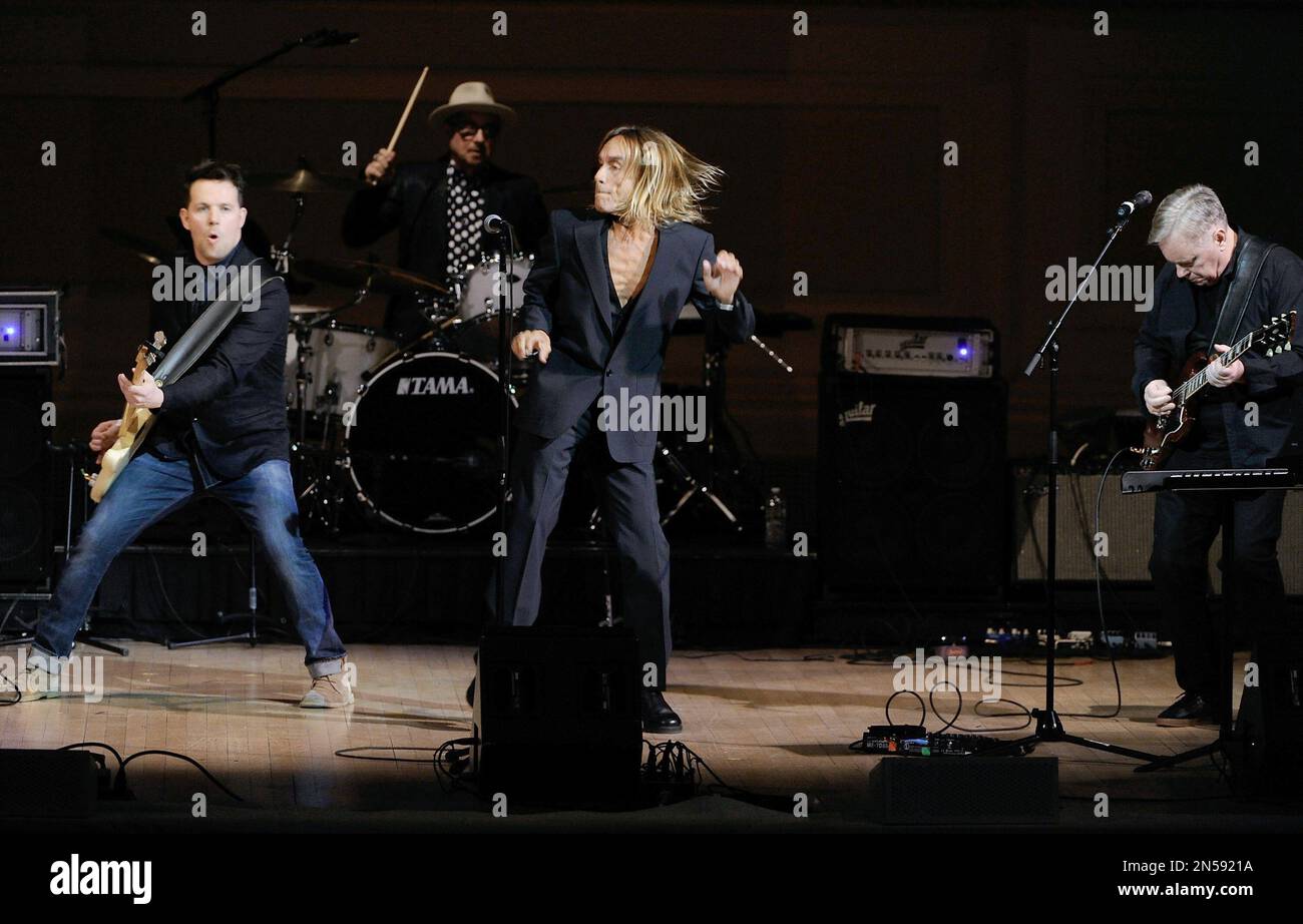 Singer Iggy Pop, center, performs with Bernard Sumner, right, and Tom ...