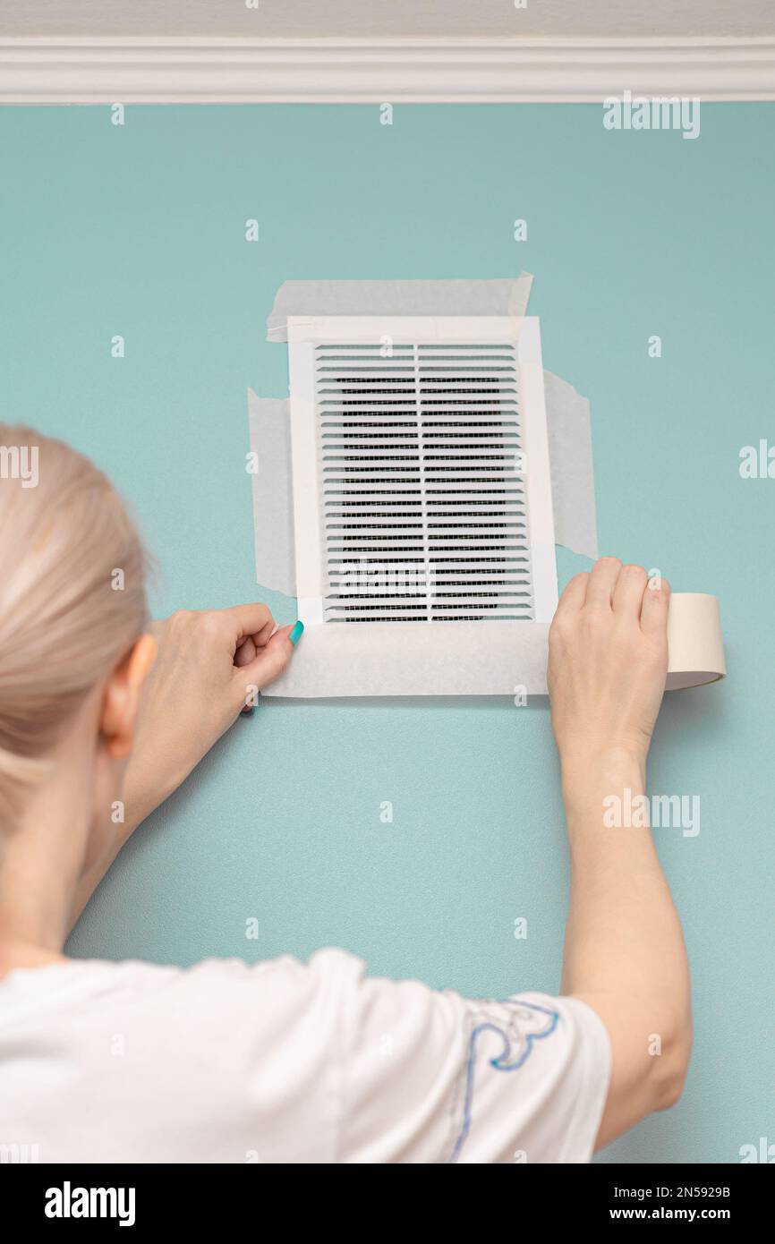 a man installs a grate on an air vent. ventilation grille in the house ...