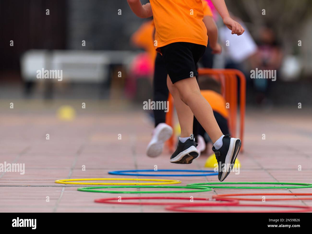 Competitive active game, children jump over obstacles Stock Photo - Alamy