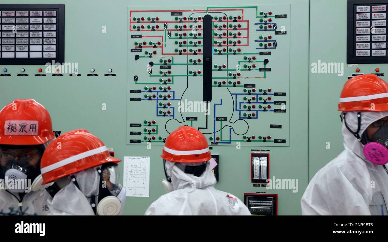 Journalists wearing protective gears tour to the central control room ...