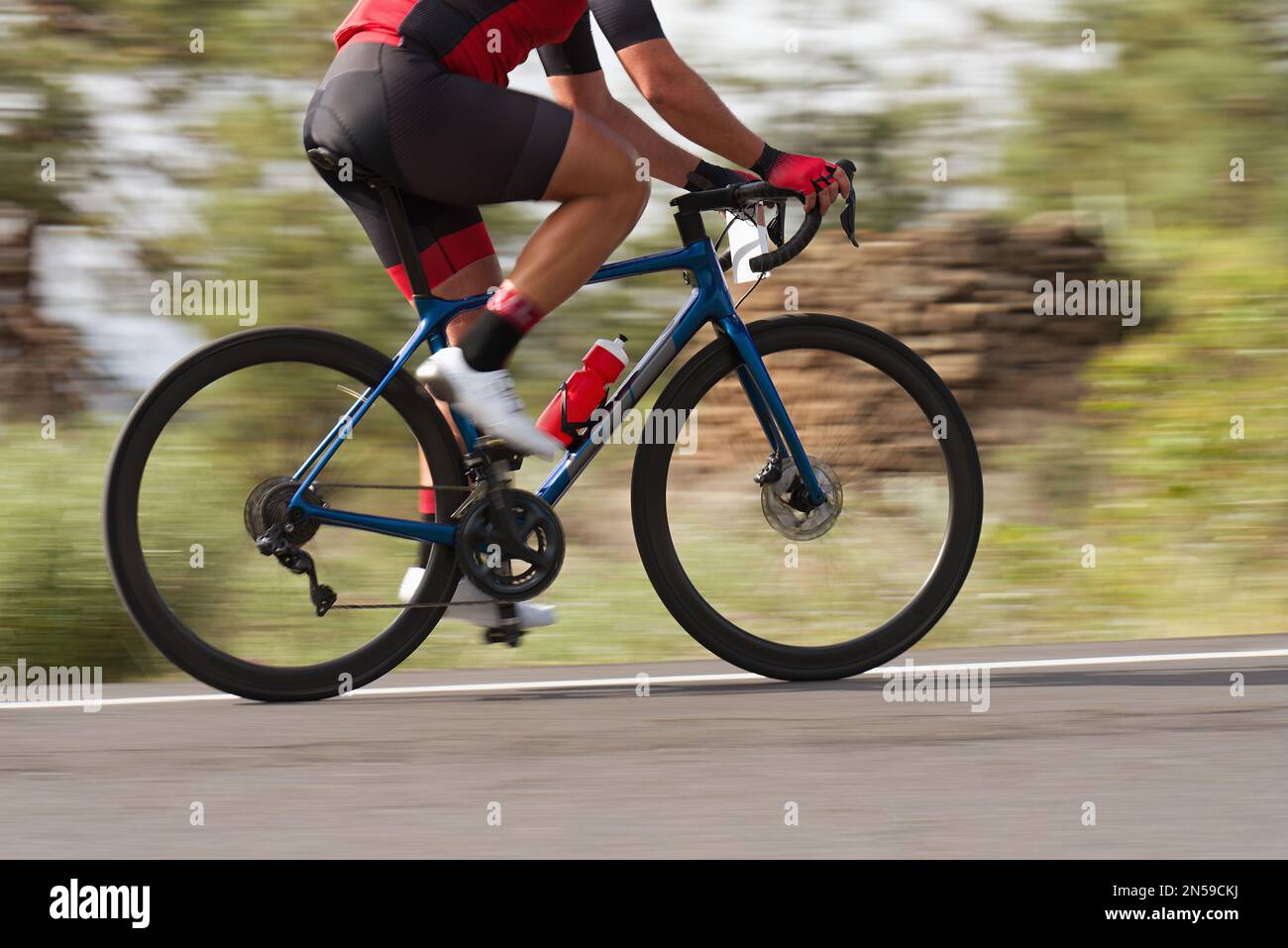 Road bike cyclist man cycling, athlete on a race cycle. Panning ...