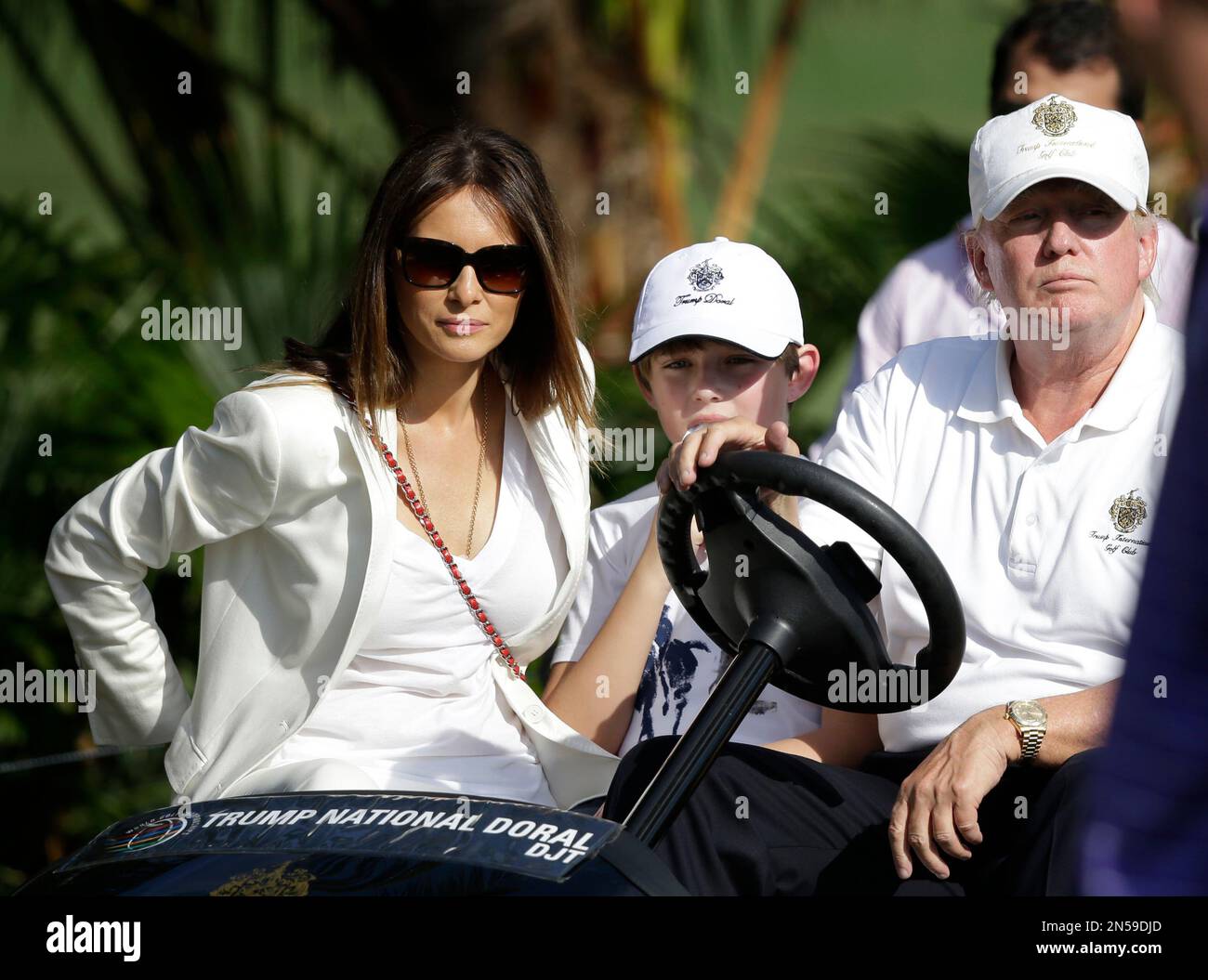Donald Trump drives his wife Melania and son Barron around the golf ...