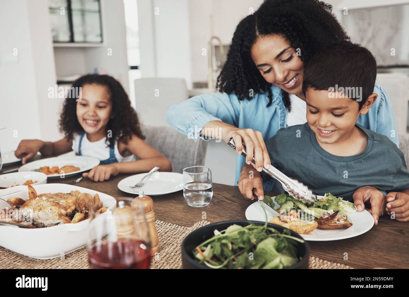 Mom, children and eating food in home together for lunch, dinner table ...