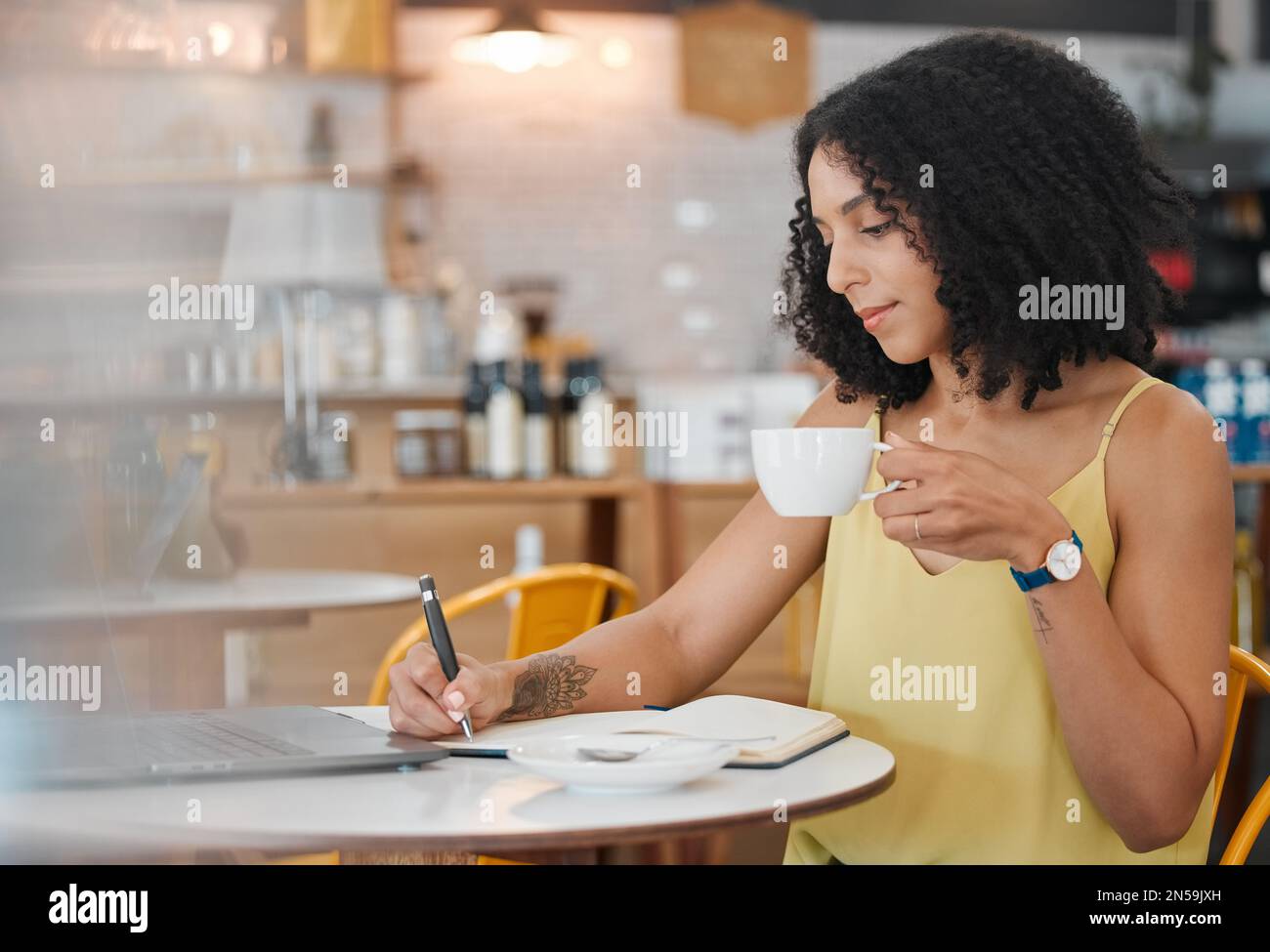 Cafe, freelancer and woman writing notes for a freelance project while ...
