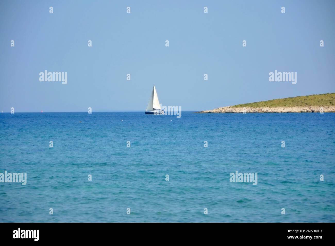 Sailing boat defront isolated island with open sails.Classic sailboat ...