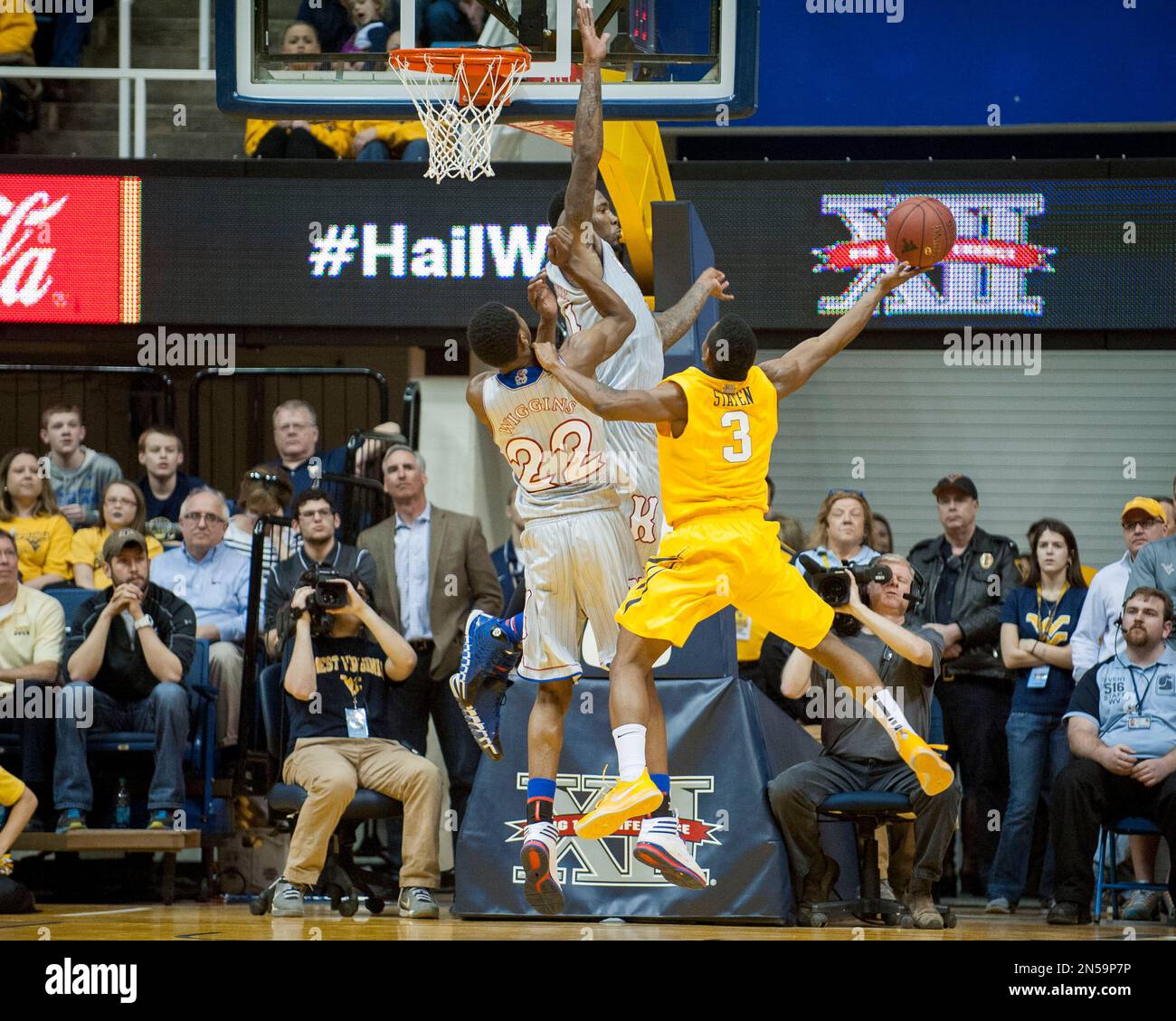 West Virginia's Juwan Staten, right, drives to the basket as Kansas ...