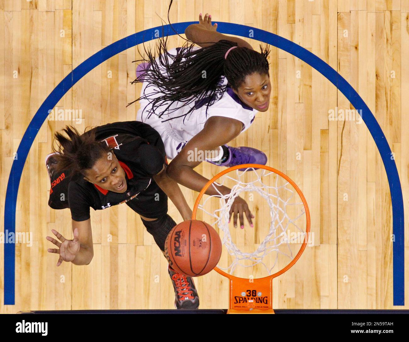 Texas Tech guard Amber Battle, left, watches her shot in front of TCU ...