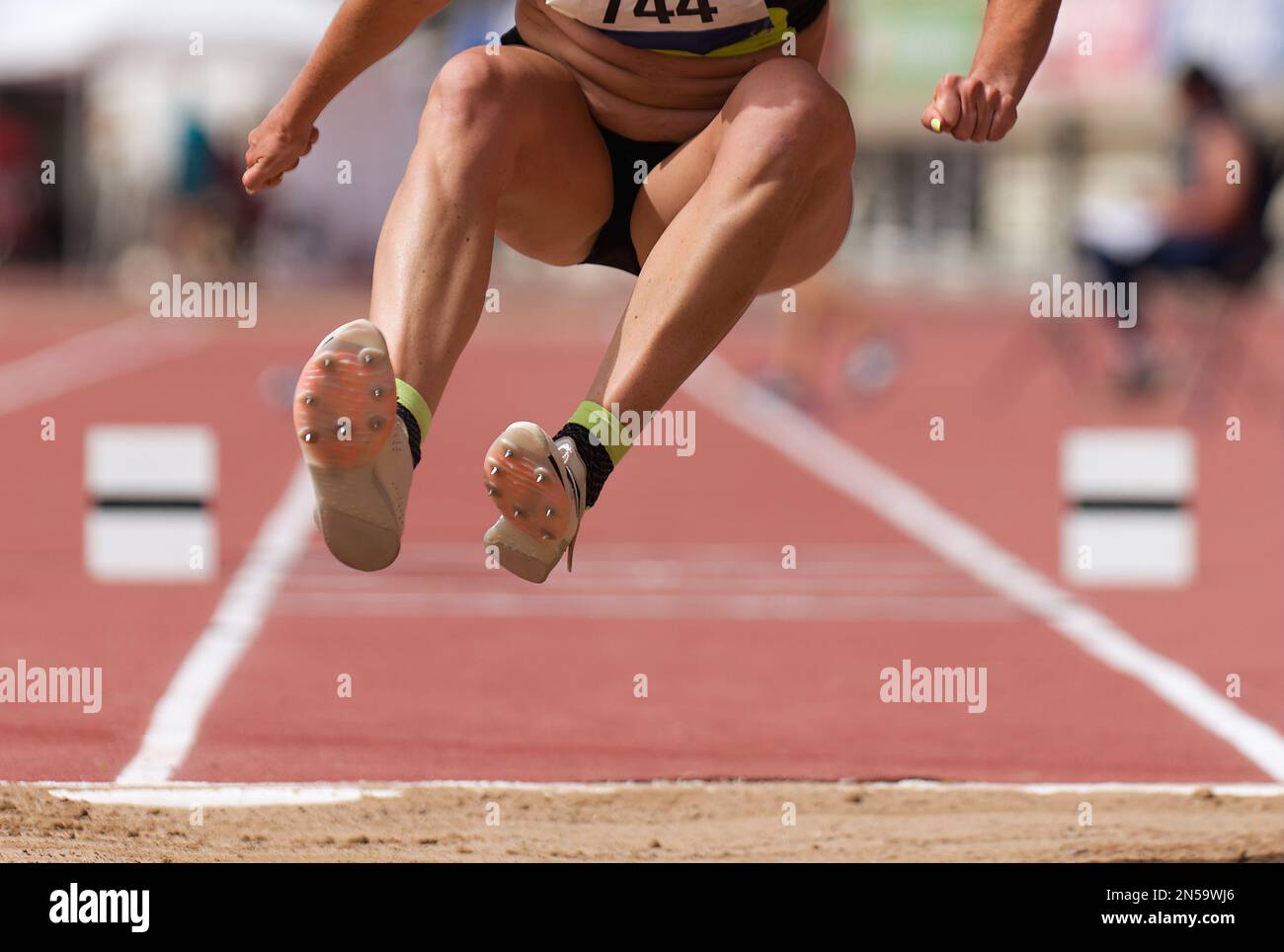 Female athlete performing a long jump during a competition at stadium ...