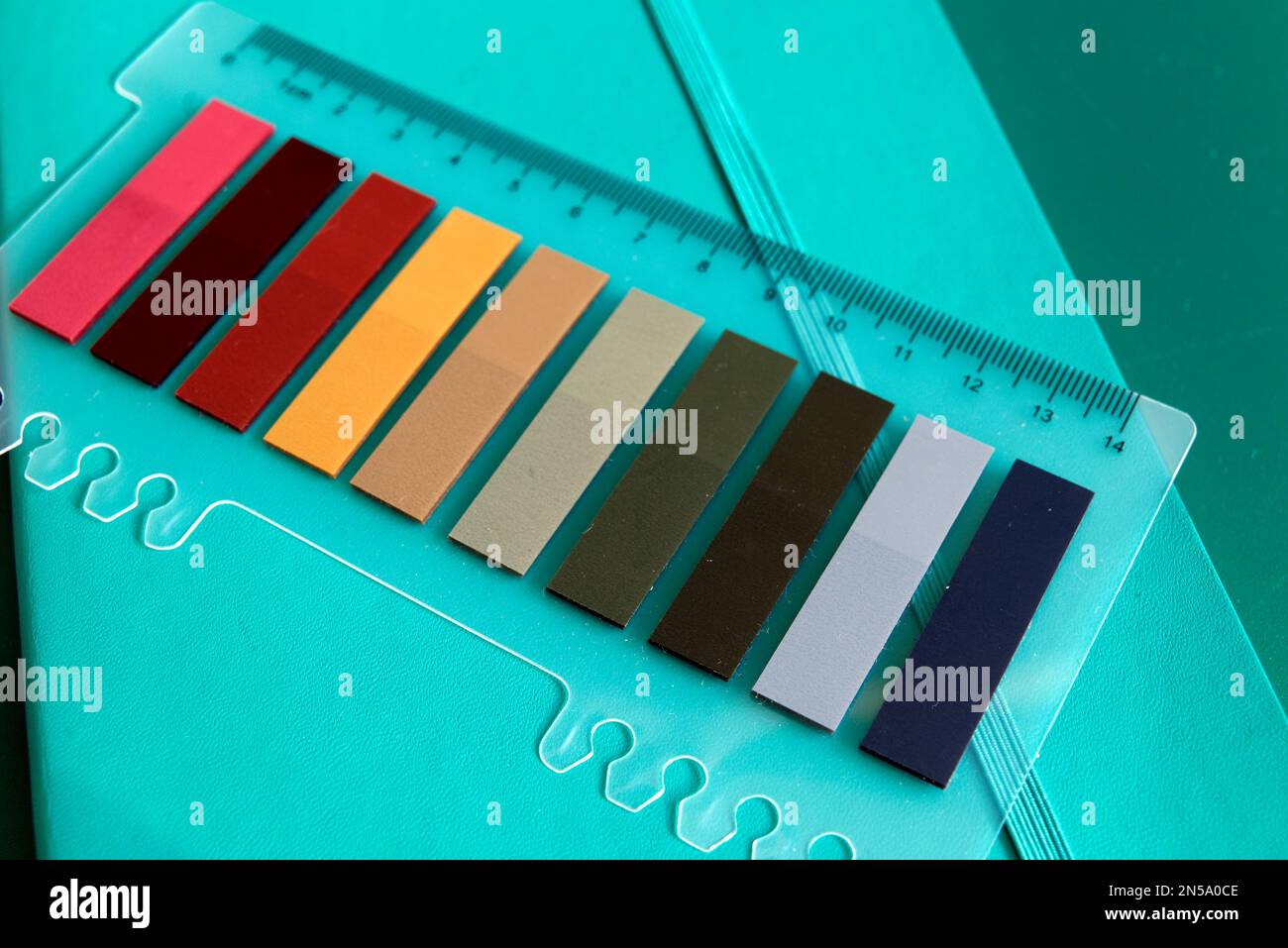 set of colorful sticky notes or paper tags and ruler on mint green ...