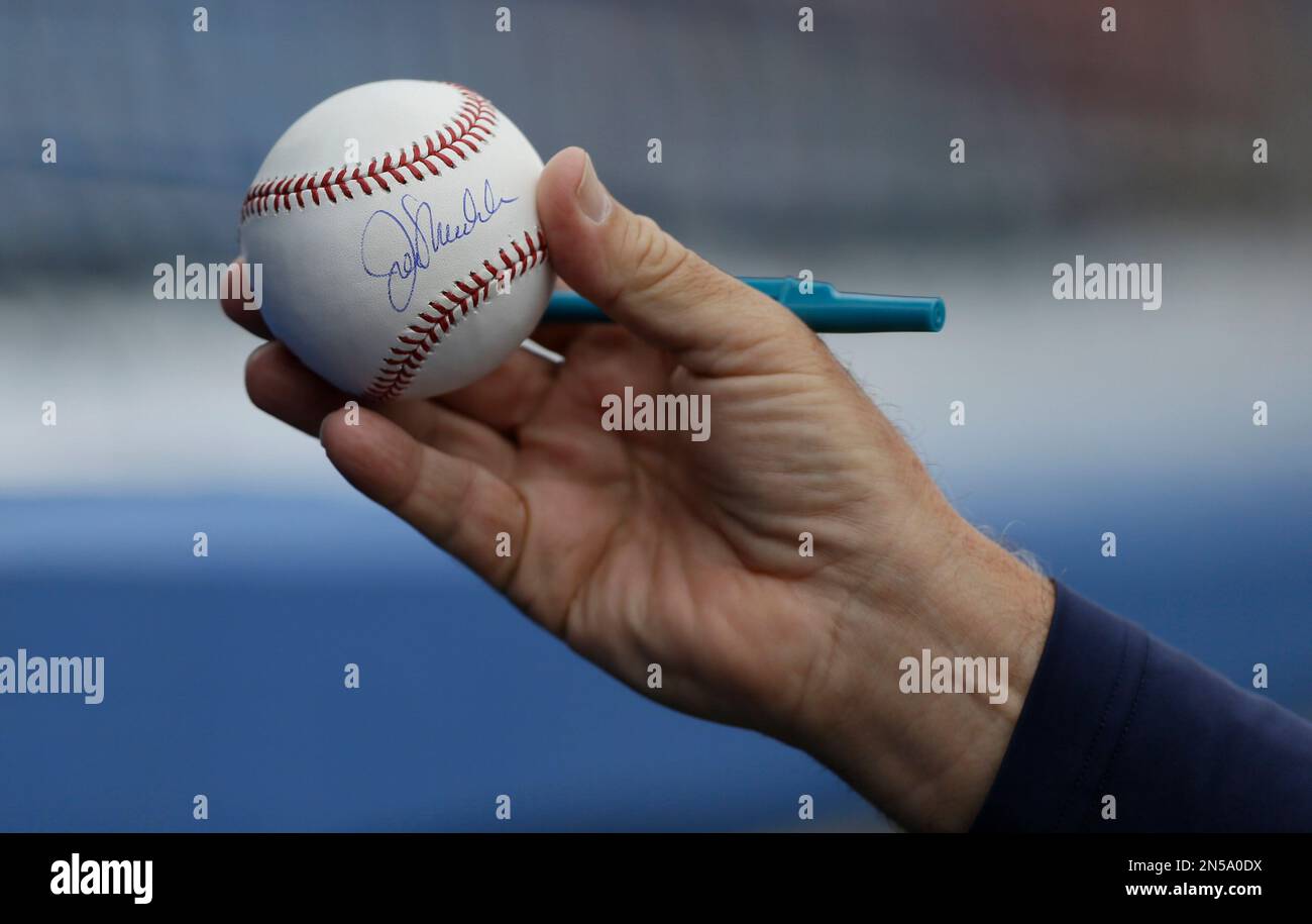 Tampa Bay Rays manager Joe Madden hands an autographed baseball to a ...