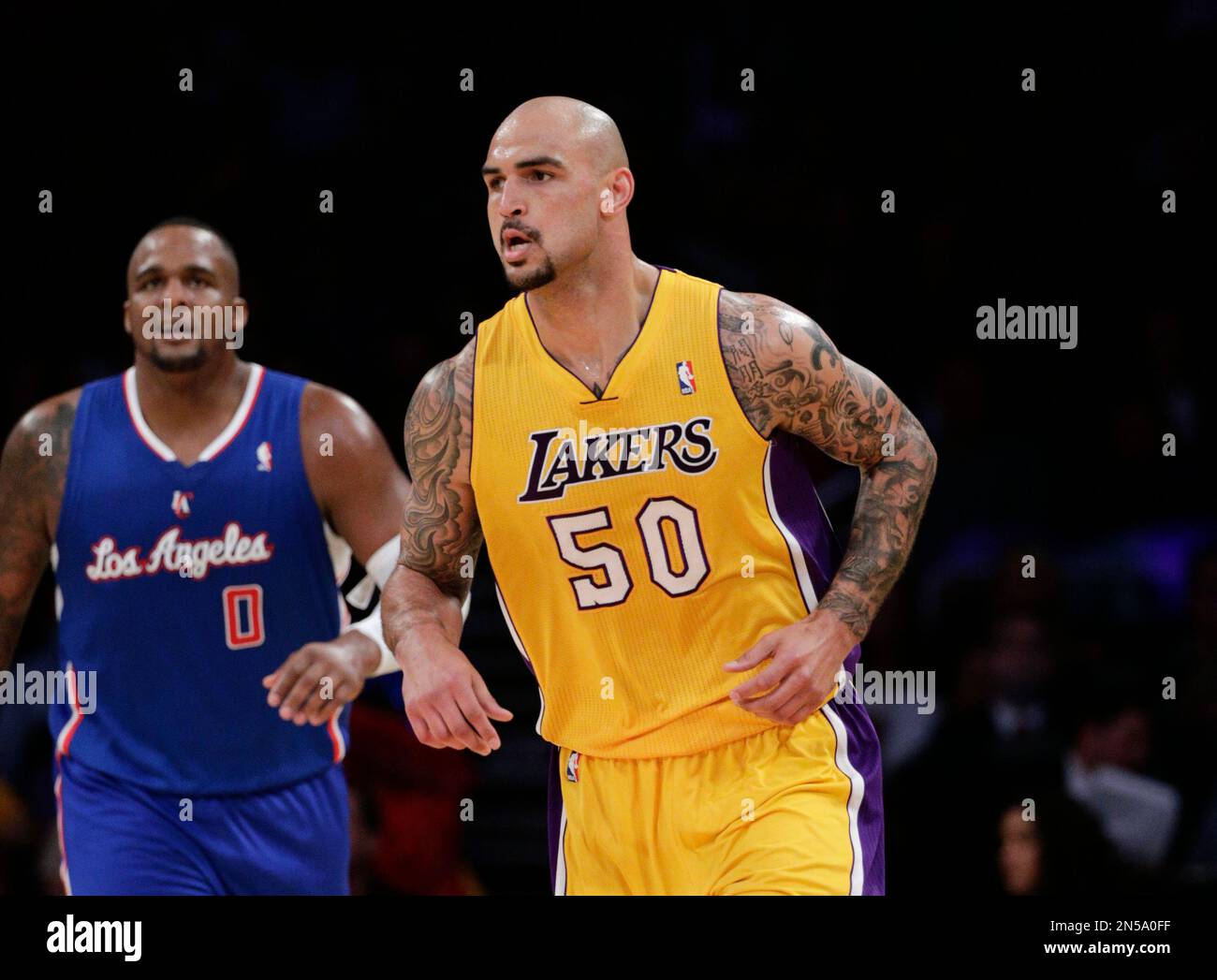 Los Angeles Lakers' Robert Sacre makes his way down the court during ...
