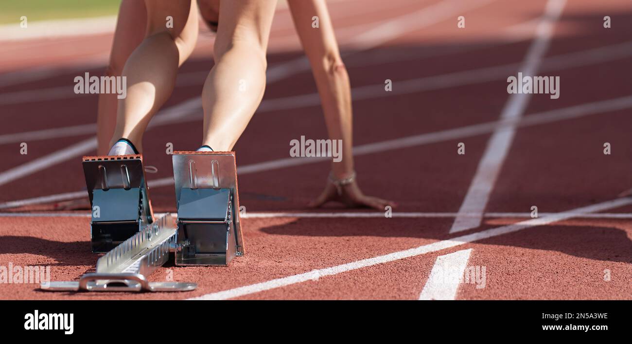 Back view of female feet on starting block ready for a sprint start ...