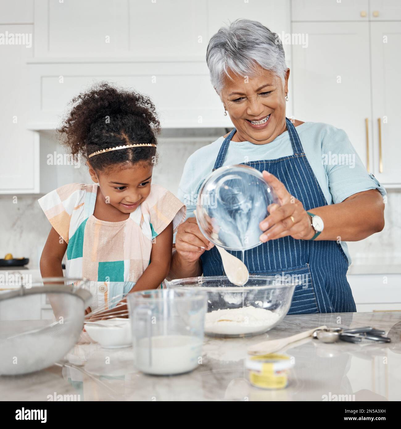 Learning, cooking and grandmother with girl in kitchen mixing milk and ...