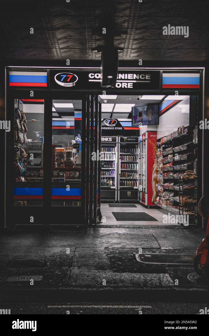 A closeup of the "77" convenience store entrance in Auckland at night ...