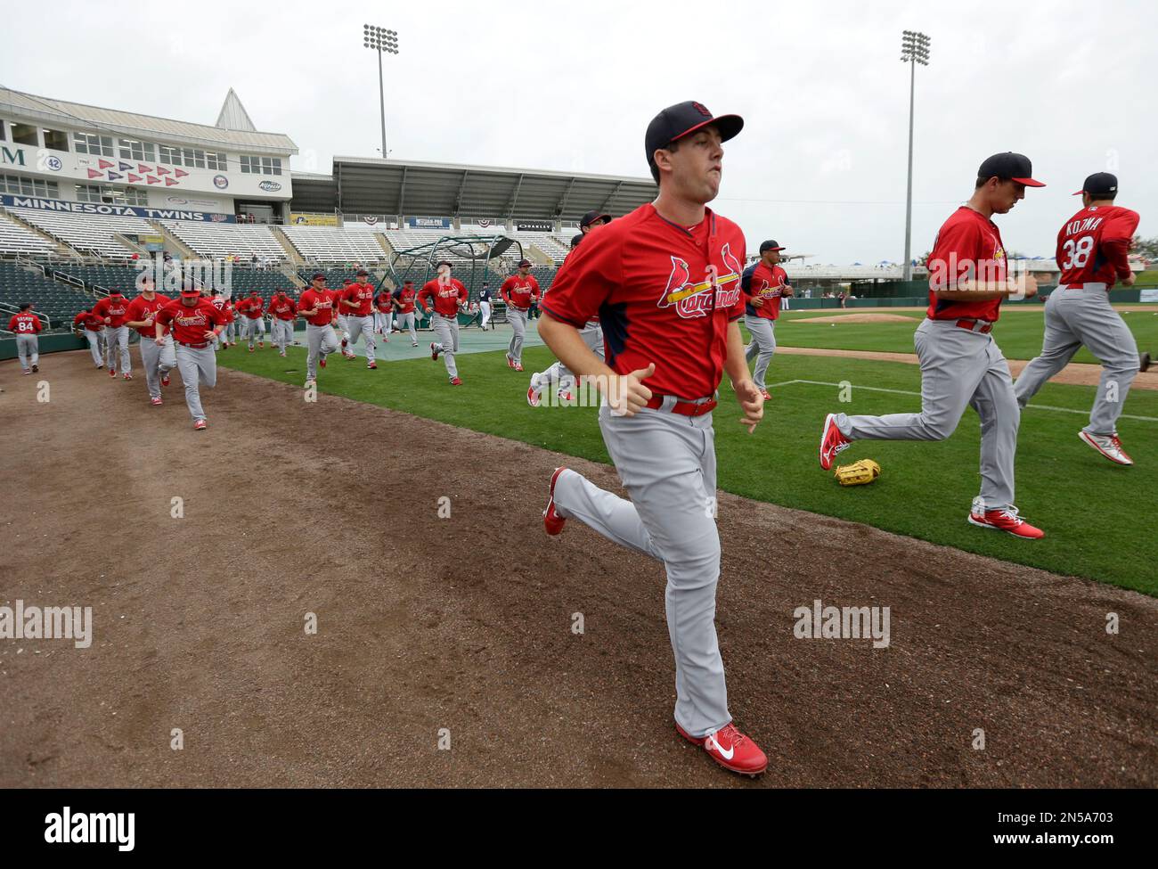 St. Louis Cardinals pitcher Tim Cooney, front, warms up with teammates ...