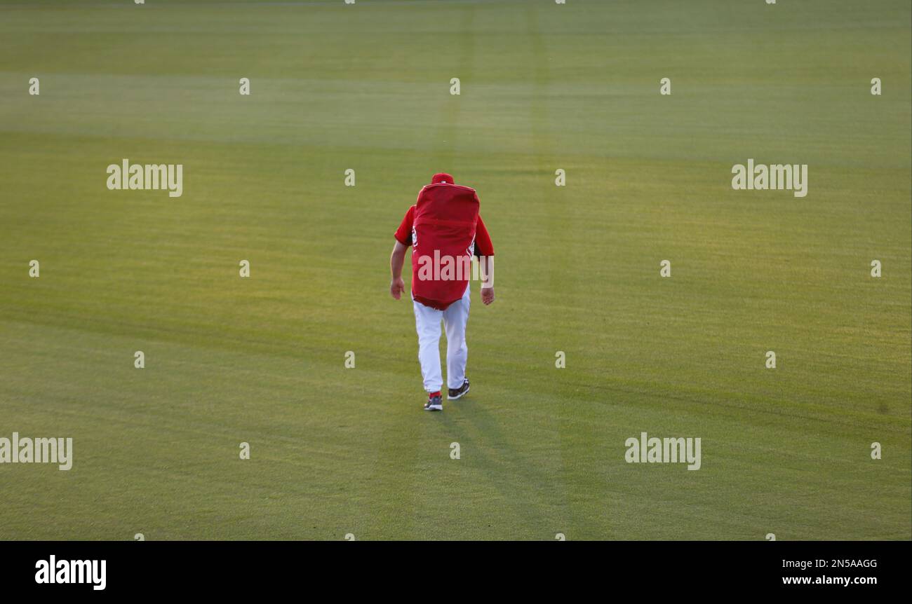 Cincinnati Reds catcher Corky Miller carries his bag to the dugout ...