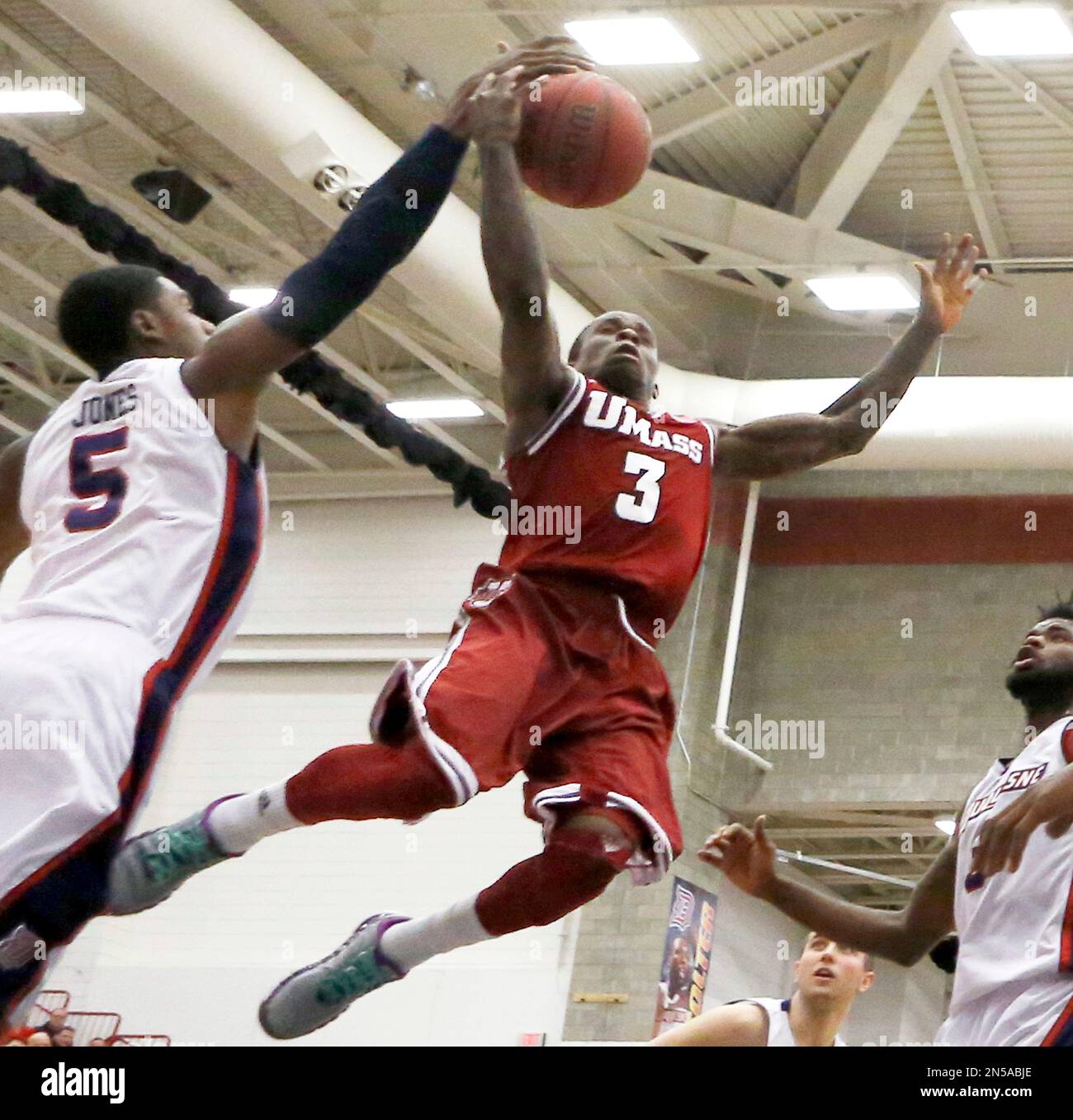 Massachusetts' Chaz Williams (3) shoots past Jerry Jones (5) during the ...