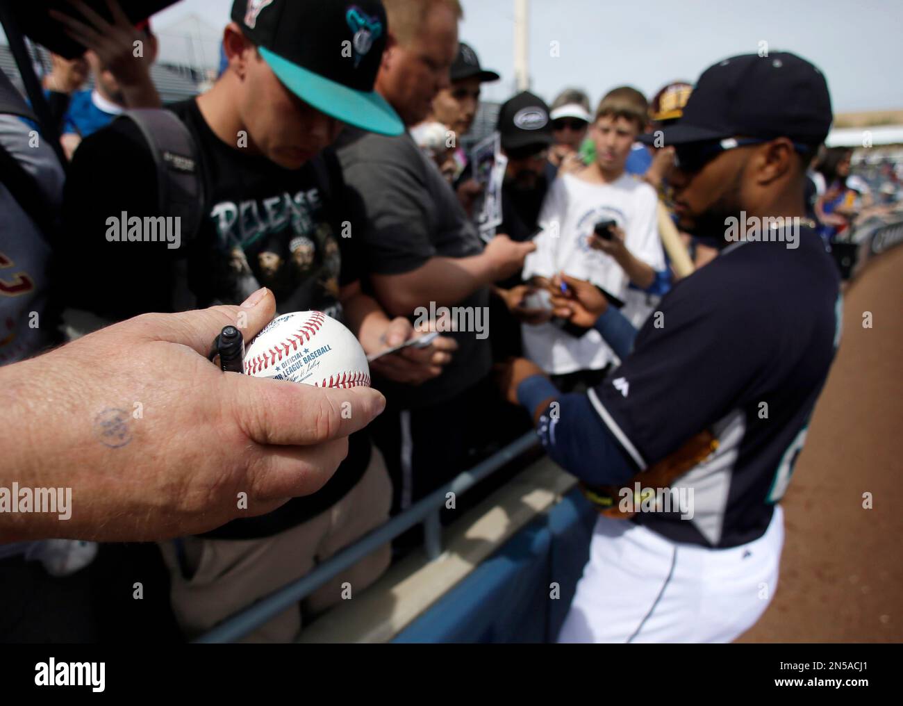 Seattle Mariners' Robinson Cano signs autographs for fans before a ...