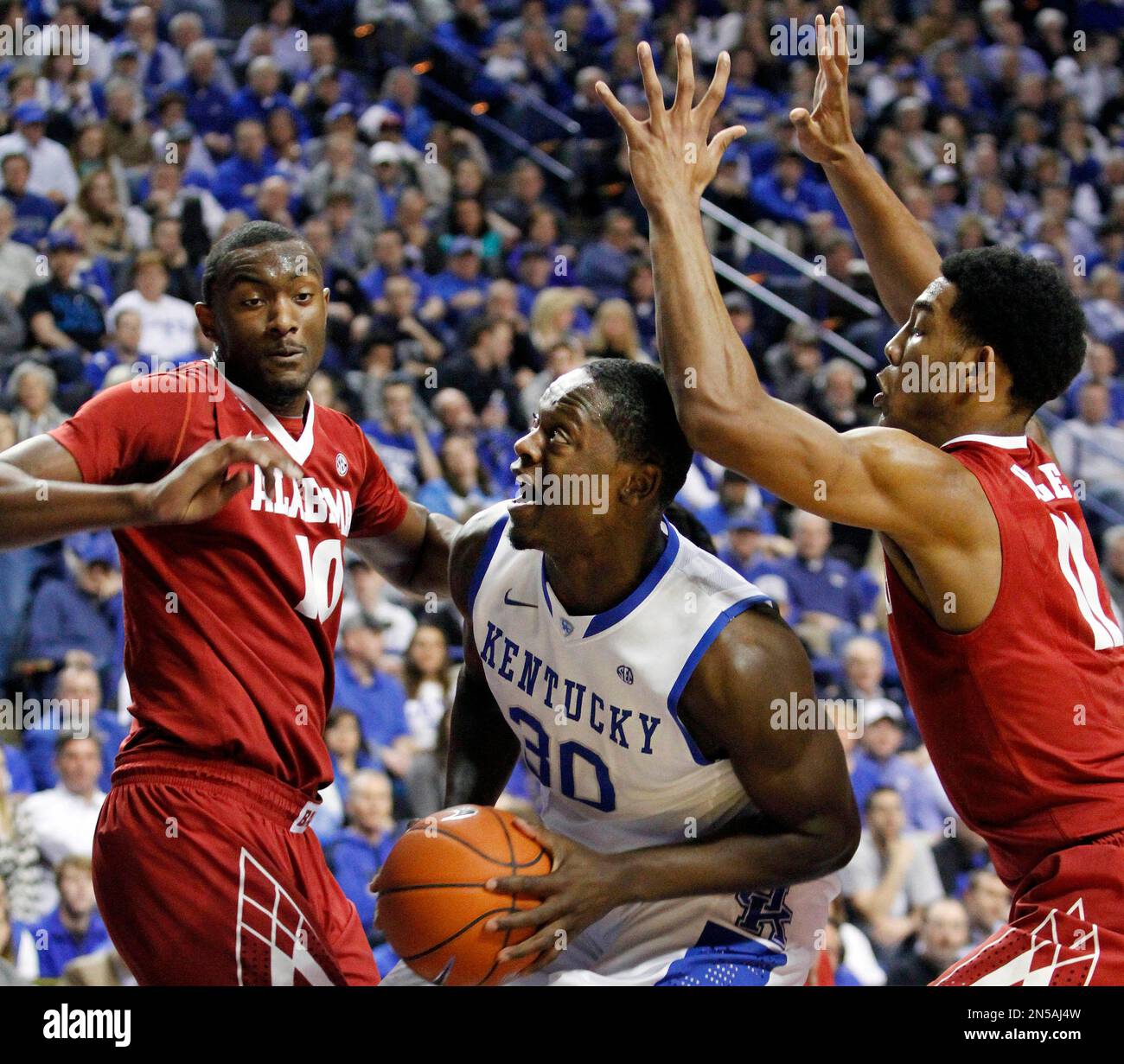 Kentucky's Julius Randle, center, looks for an opening between Alabama ...