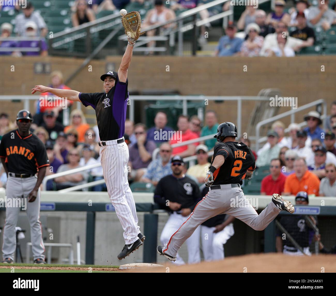Colorado Rockies catcher Matt McBride reaches for the throw to first ...