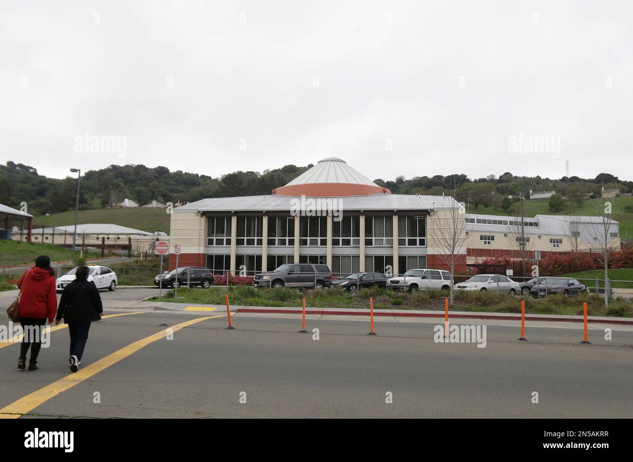 Two women cross the street toward the Hercules Middle/High School ...