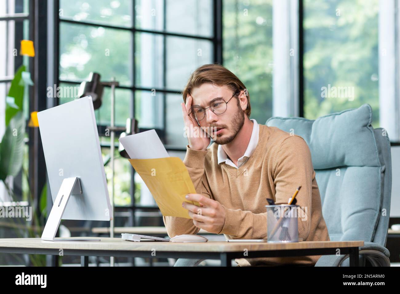 Man upset in office reading message on paper, businessman received mail ...