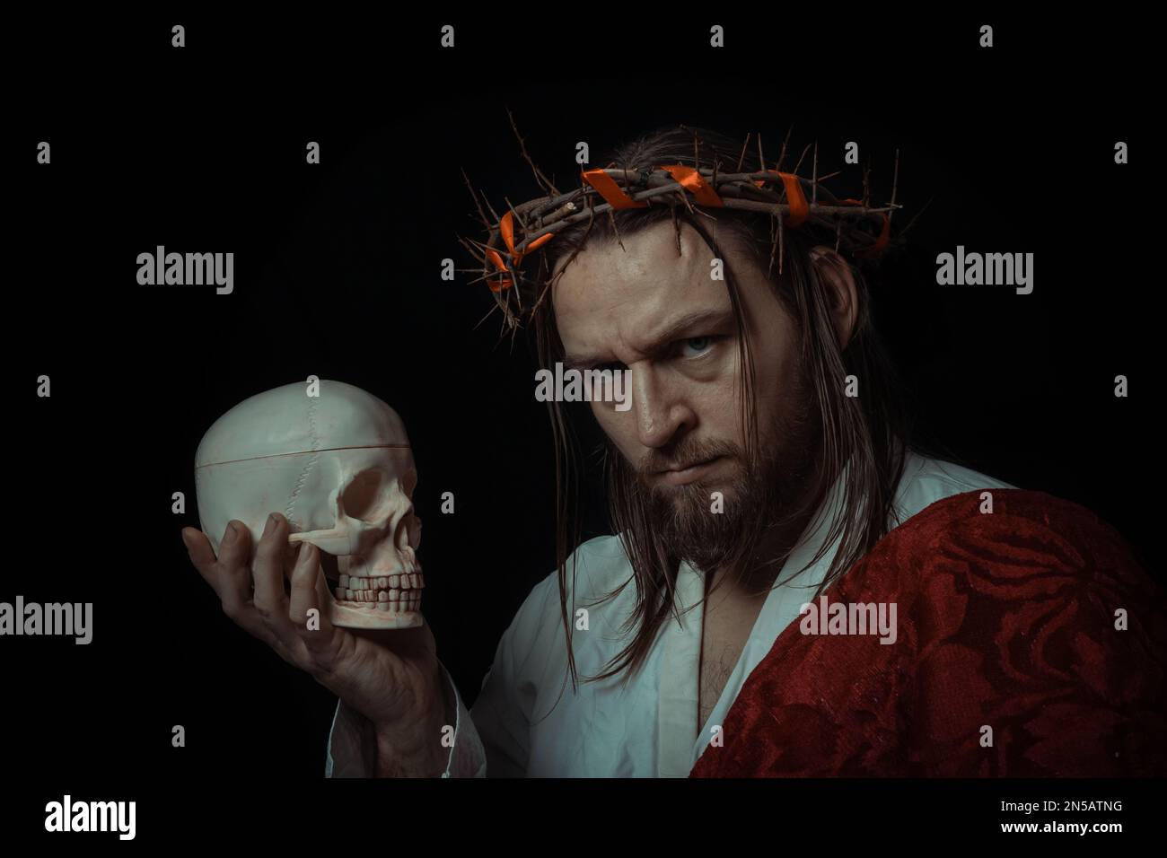 Jesus Christ with skull wearing a crown of thorns and white chiton toga ...