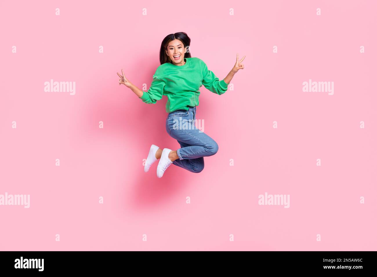 Full body photo of energetic active filipino lady jumping demonstrate v ...